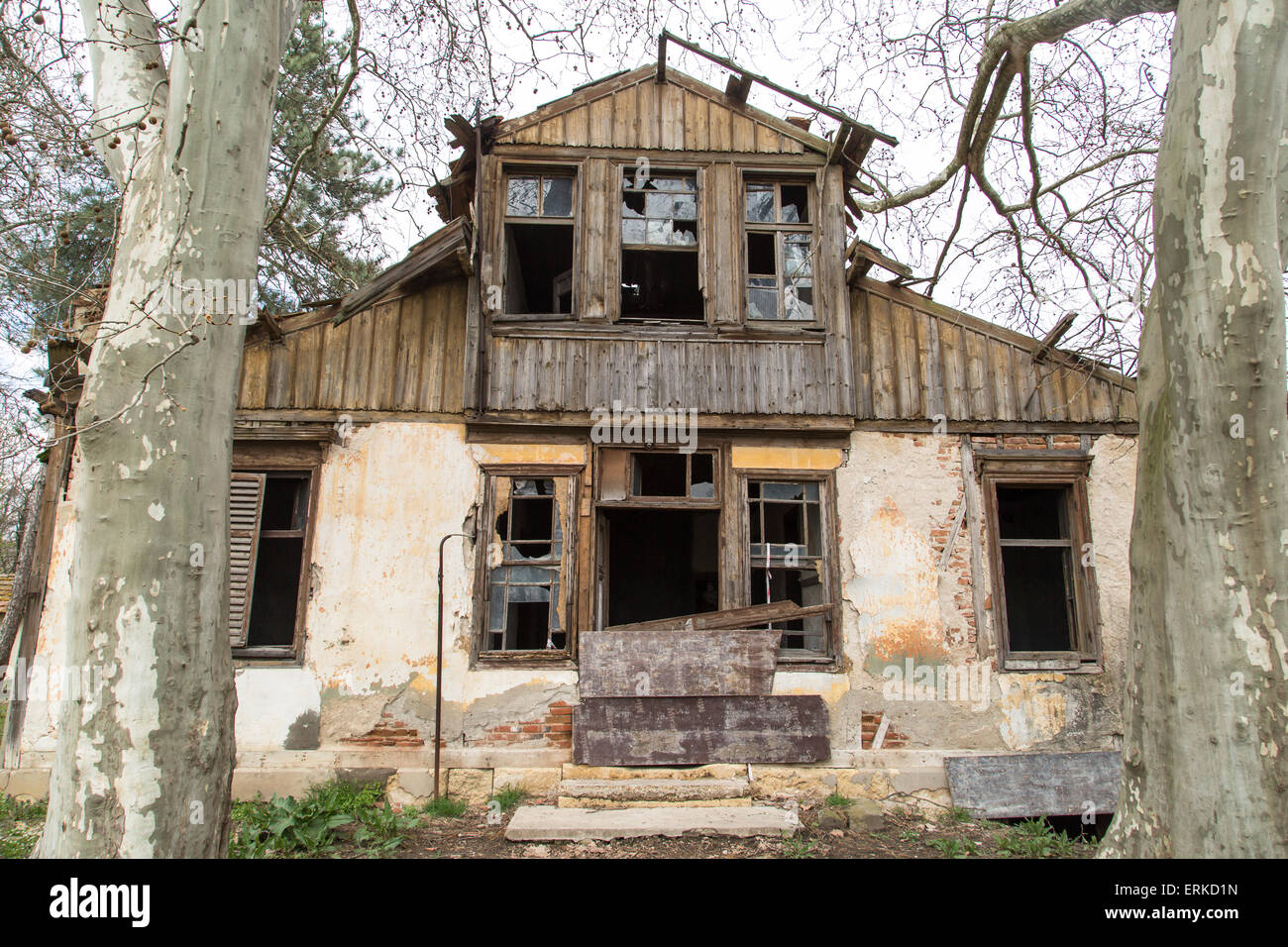 Front view of abandoned old building with dead trees Stock Photo - Alamy