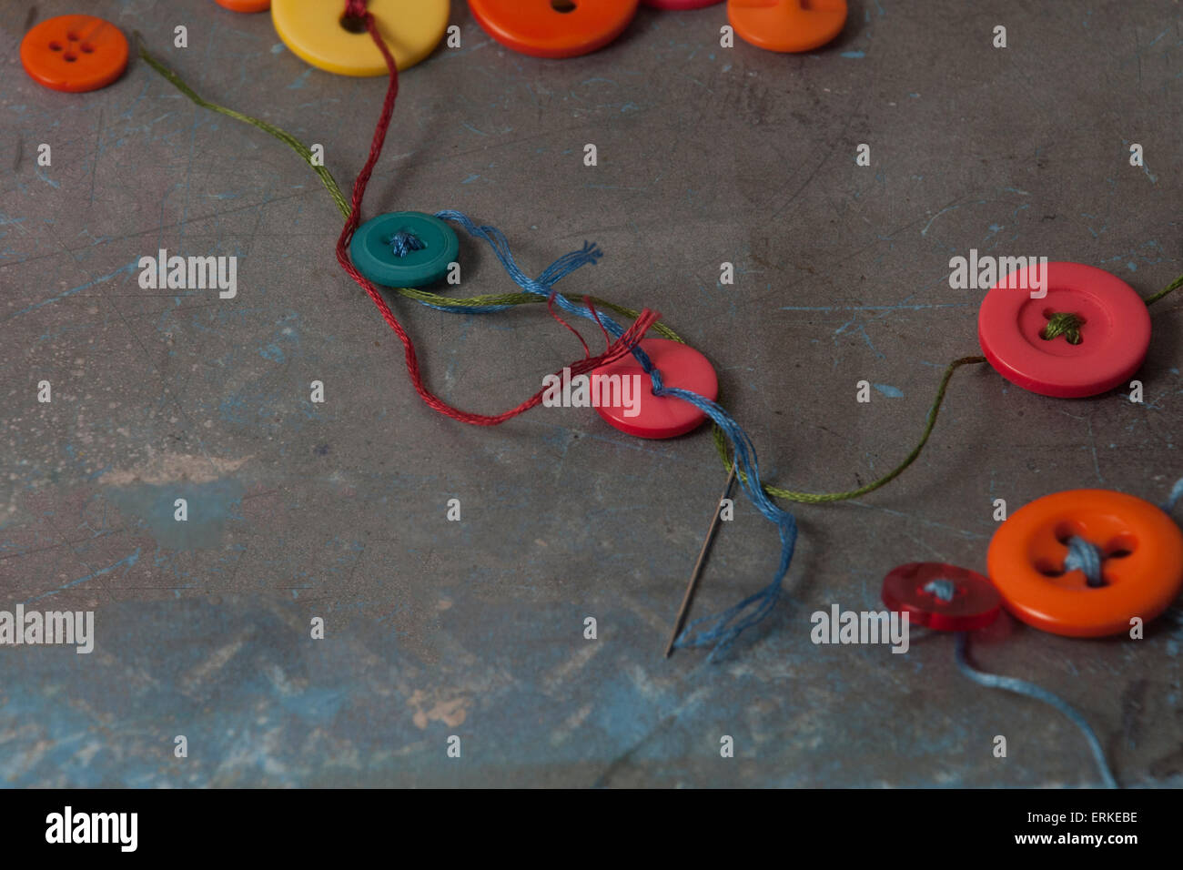 Plastic buttons and different coloured thread Stock Photo - Alamy