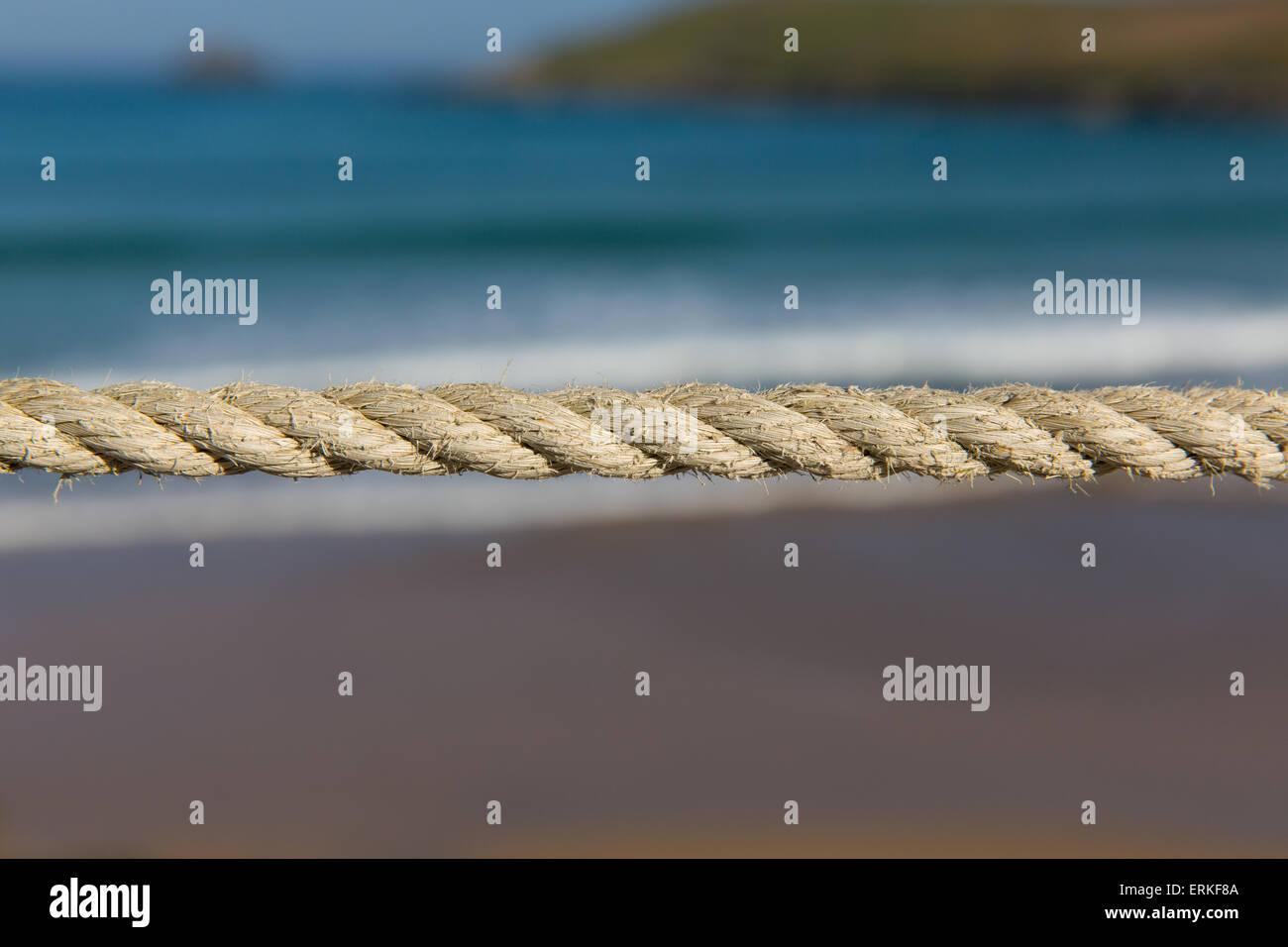 Length of rope pulled tight against a blurred background of sea waves ...