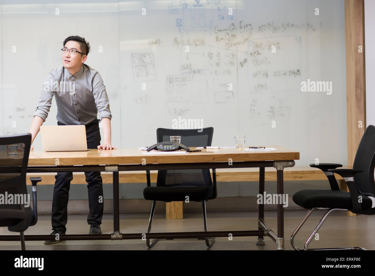 Young man thinking in board room Stock Photo - Alamy