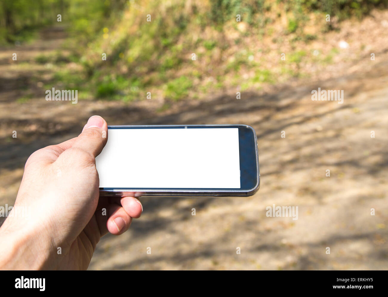 Front view of hand holding horizontal black smartphone with white blank ...