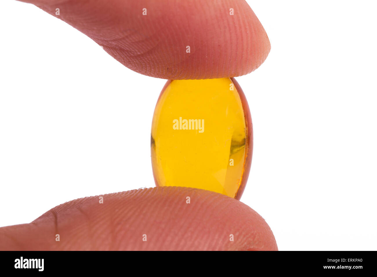 Close-up yellow pill / vitamin in hand with front view, isolated on ...