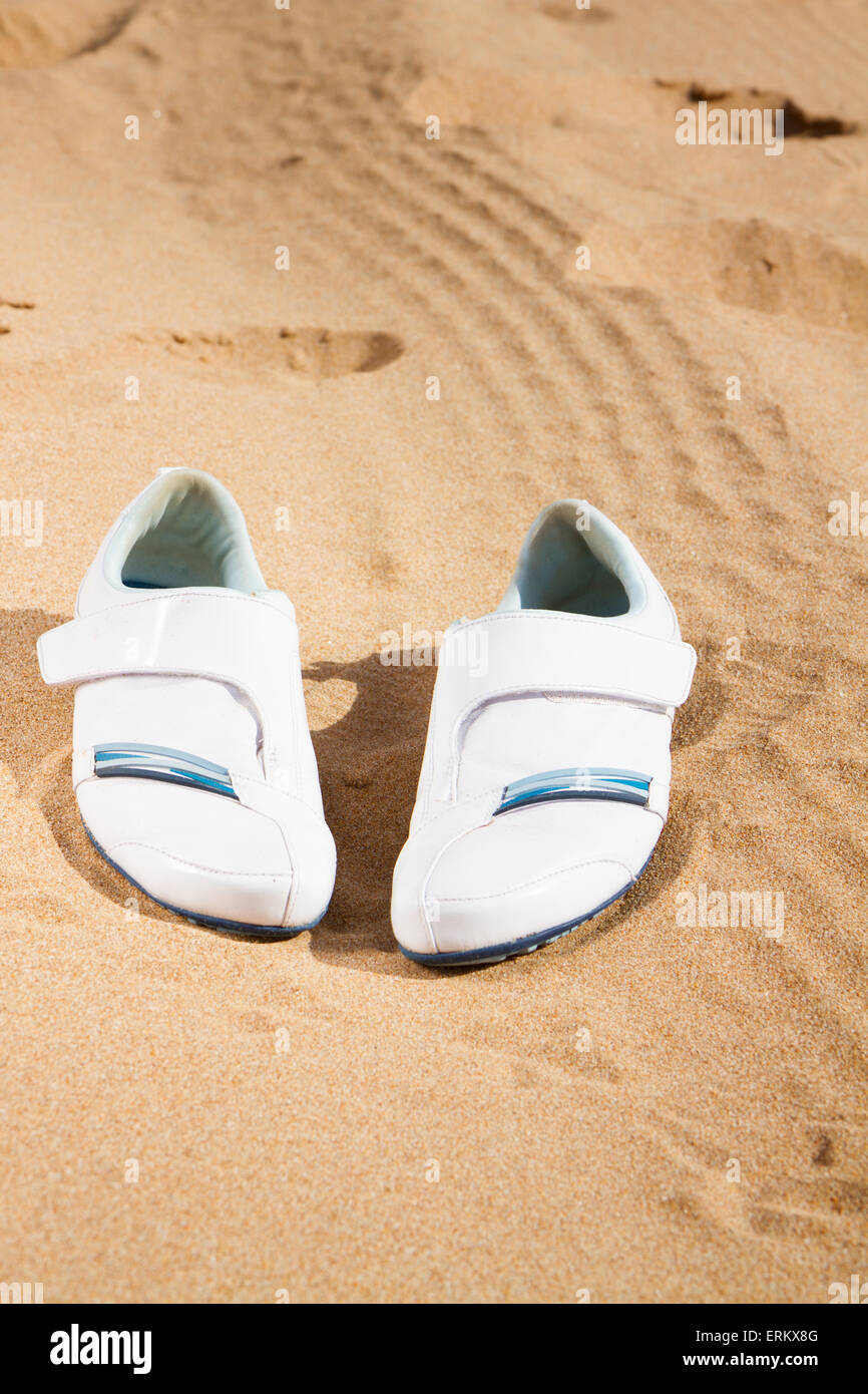 white sneakers in sand Stock Photo - Alamy