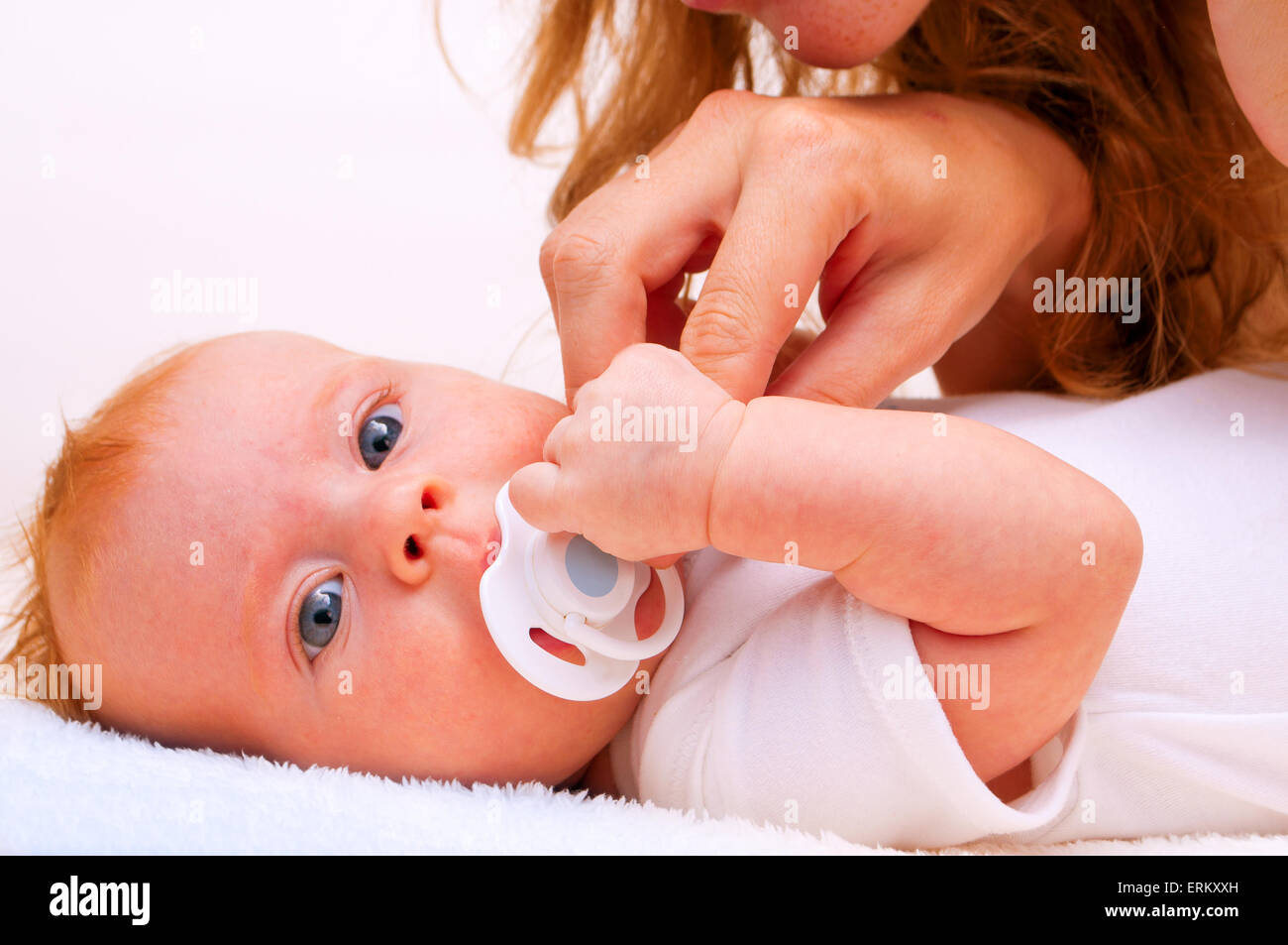Young mother trying to give baby`s dummy to newborn baby Stock Photo ...