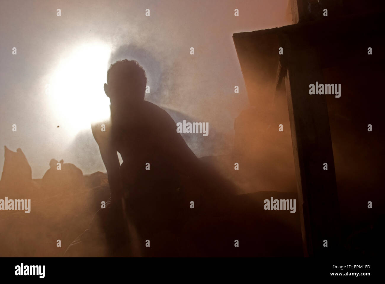 A gold mine worker removes stone dust from a stone mill in Sudan Stock ...