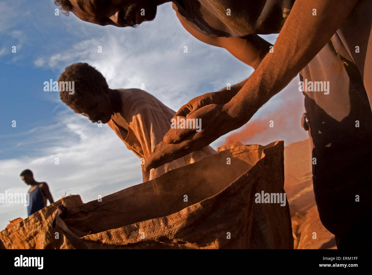 Gold mine workers looking into sacks filled with gold dust in Sudan ...