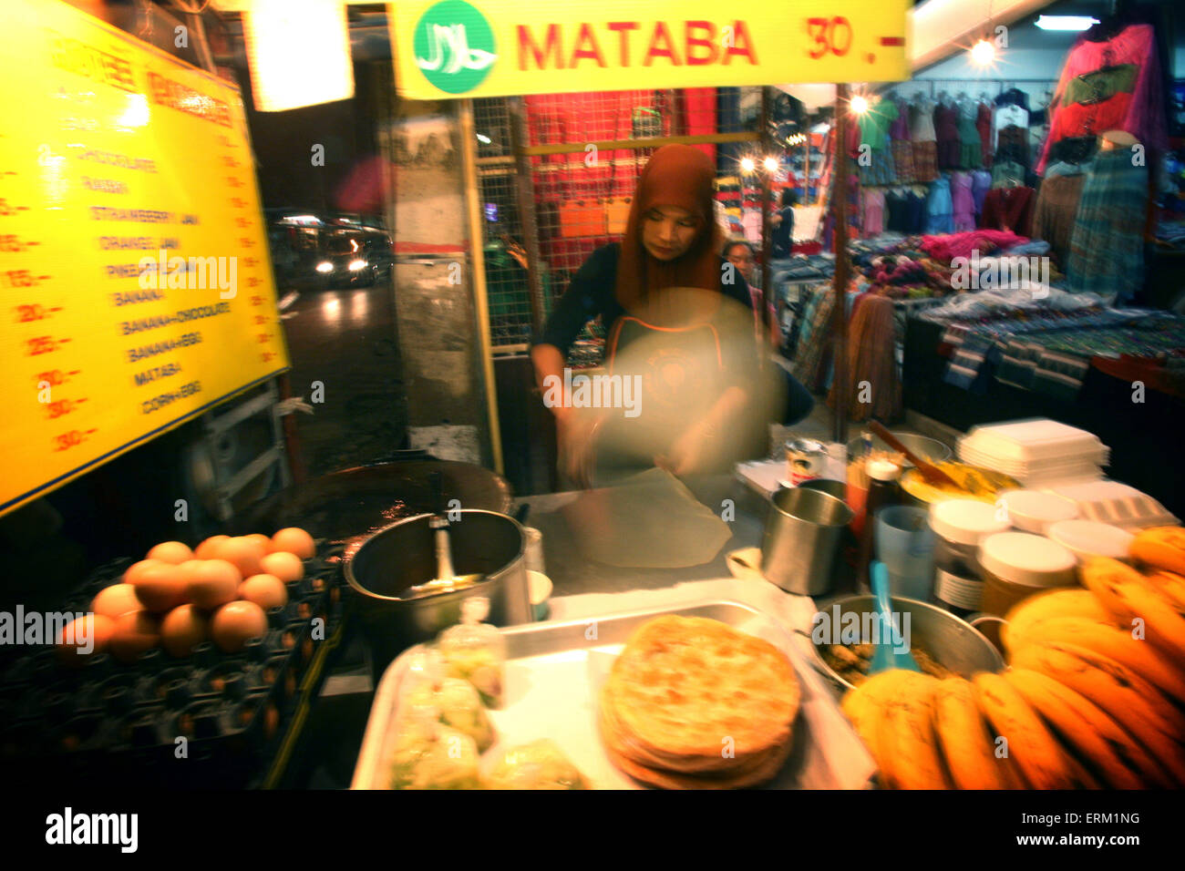 A woman cooking at the night bazaar. Chiang Mai, Thailand. (Motion Blur ...