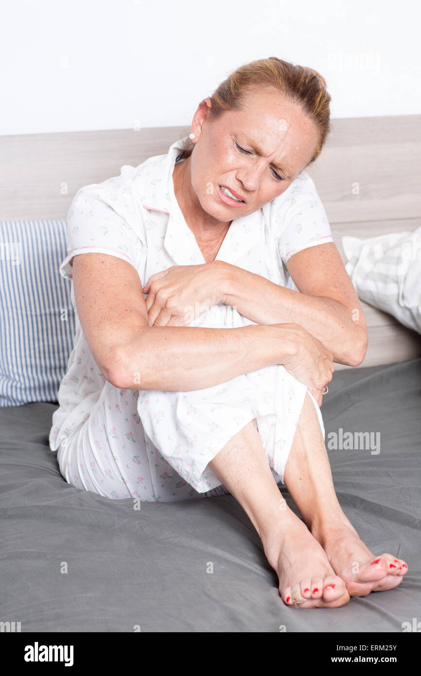 Woman crouching in pain hi-res stock photography and images - Alamy