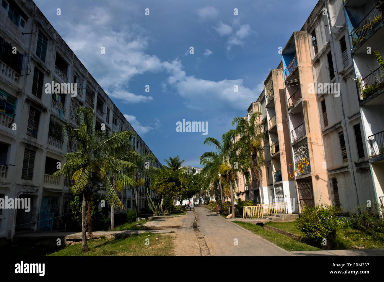 Large apartment blocks are seen on both sides of the street in a public ...