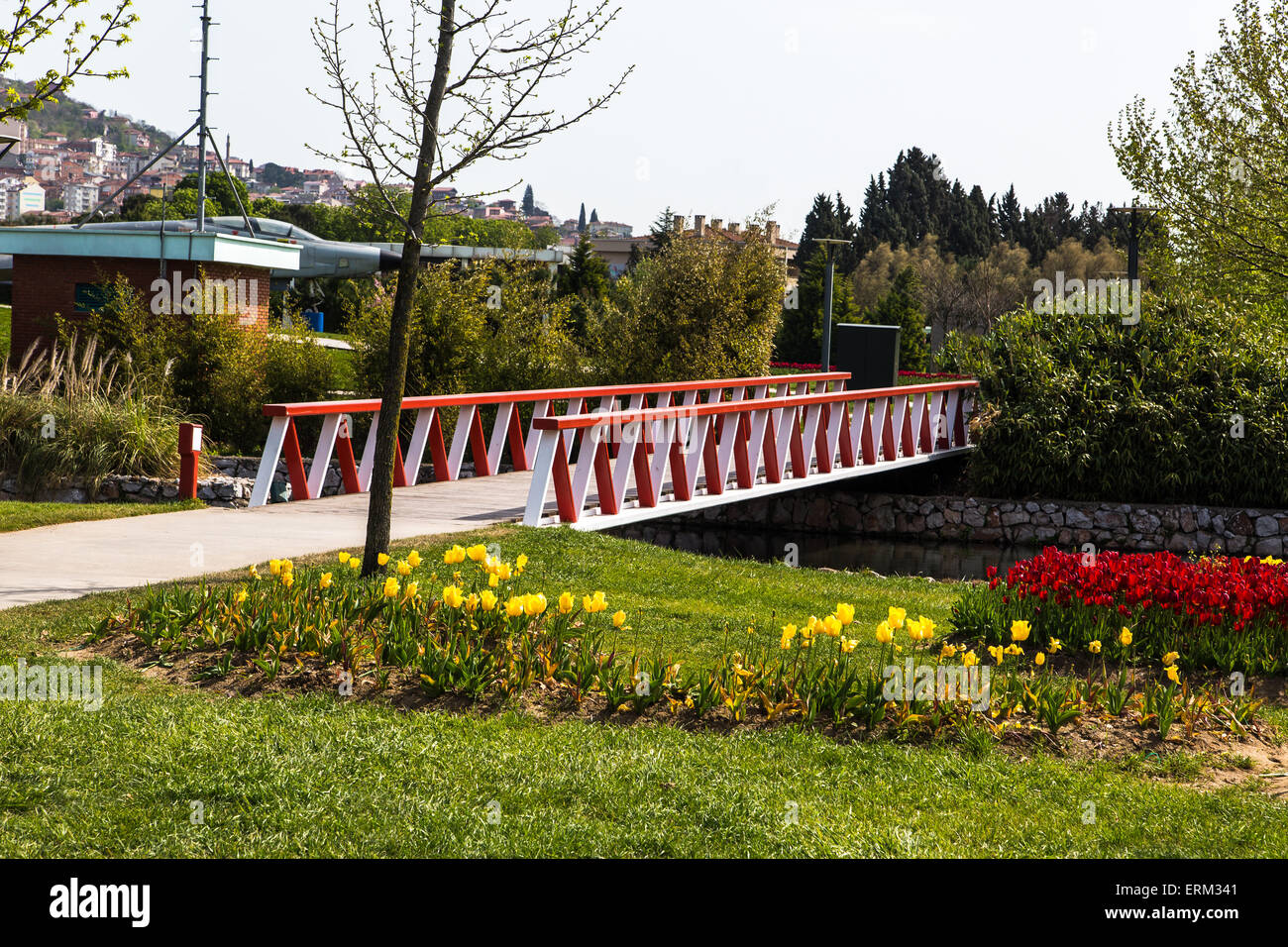 Side view of wooden bridge with red and white railing on the river ...