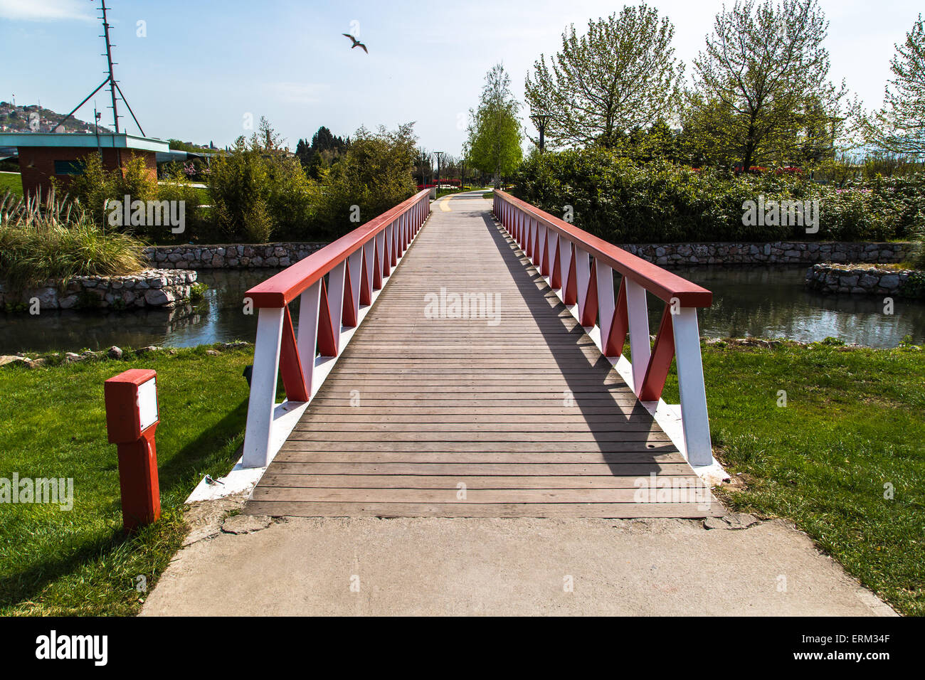 Front view of wooden bridge with red and white railing on the river ...