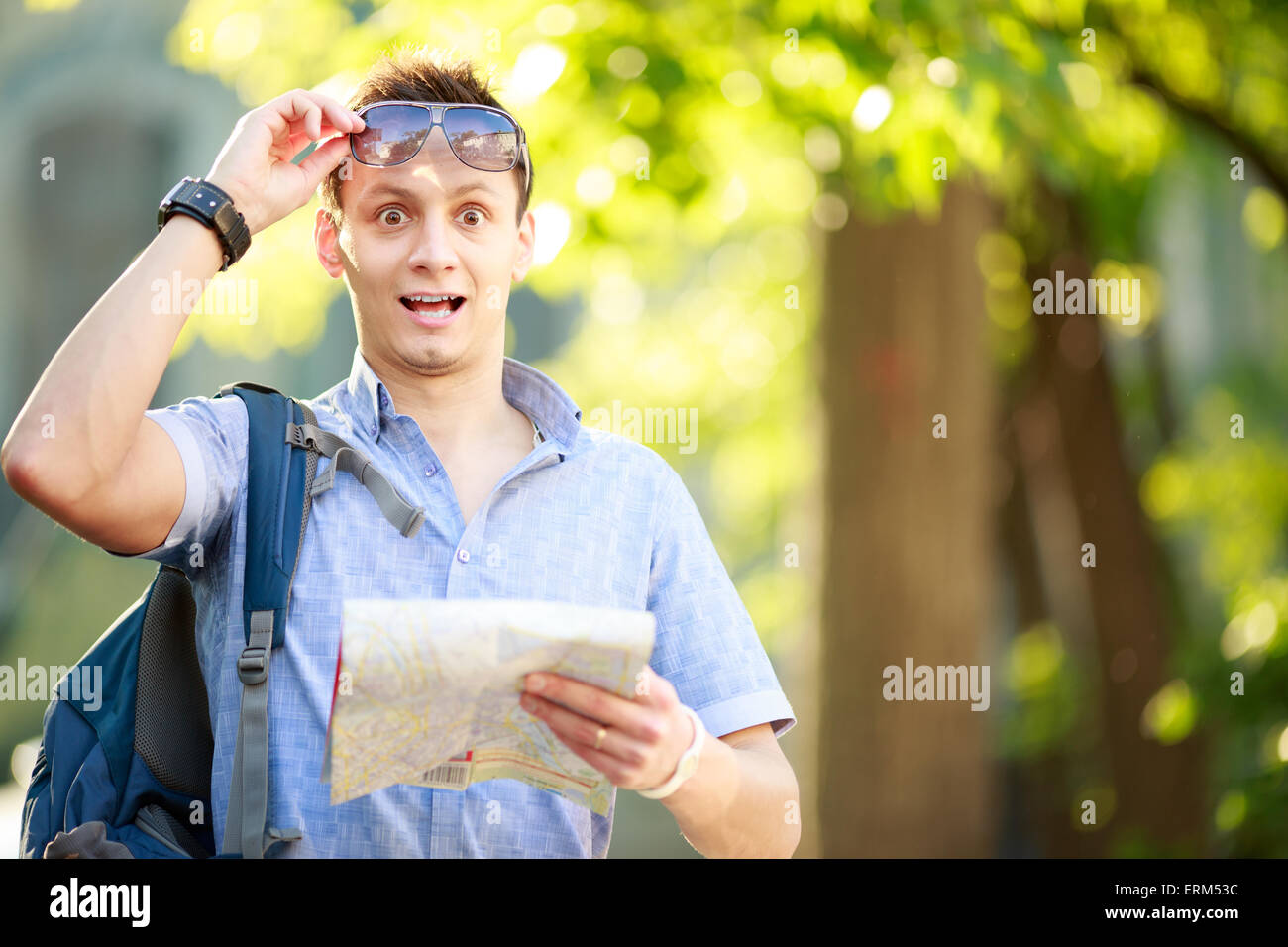 Young man with a map outdoors Stock Photo - Alamy
