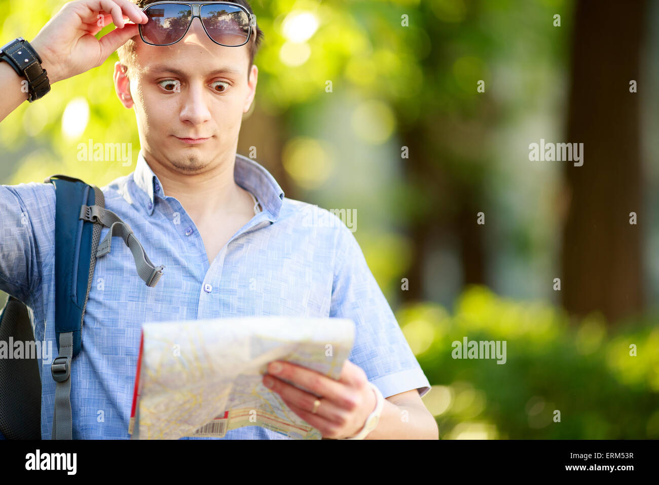 Young man with a map outdoors Stock Photo - Alamy