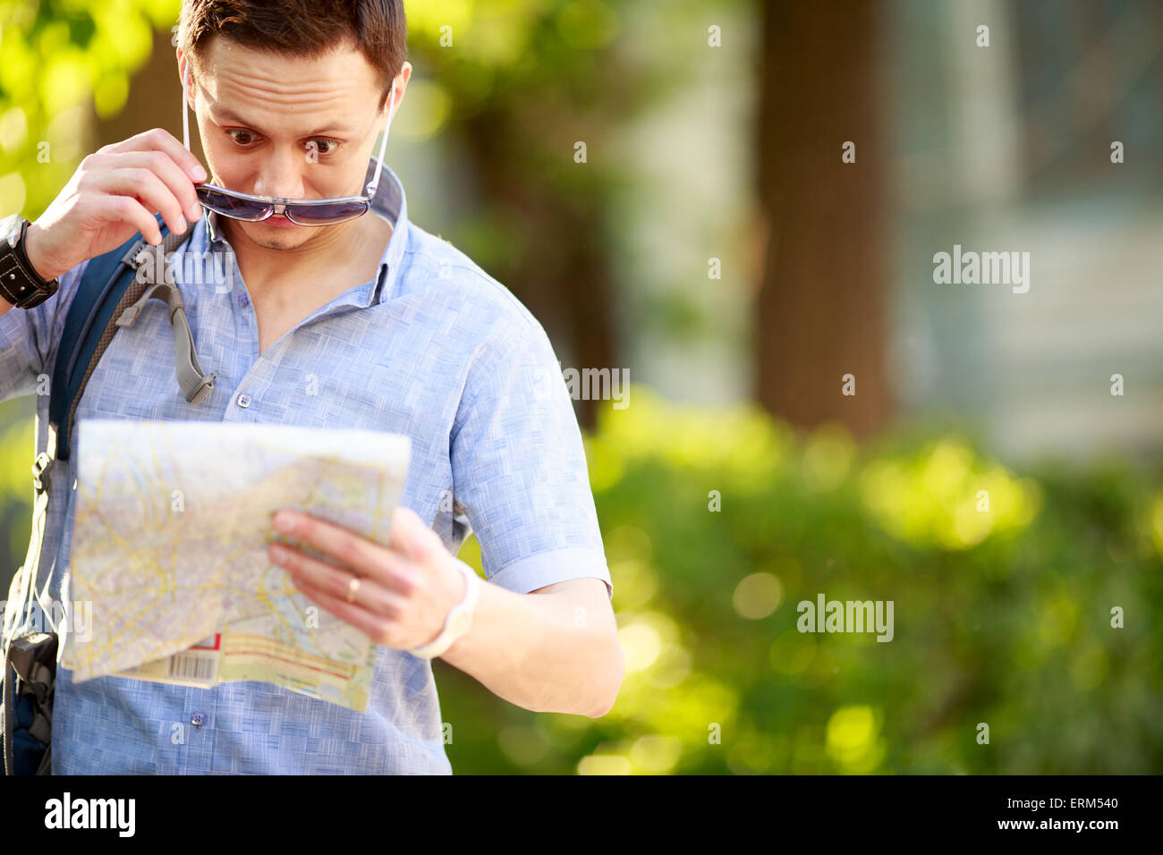 Young man with a map outdoors Stock Photo - Alamy