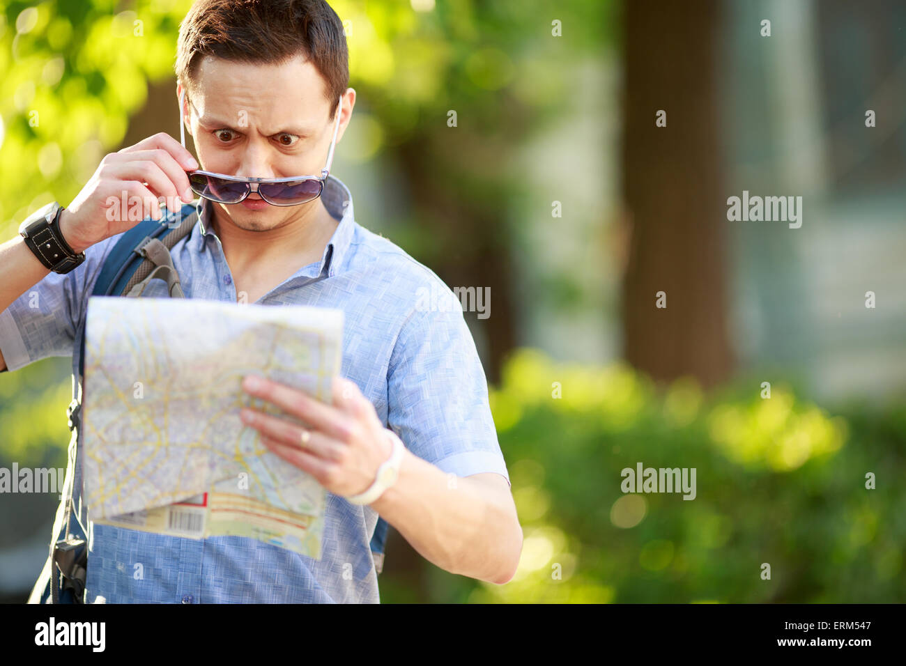 Young man with a map outdoors Stock Photo - Alamy