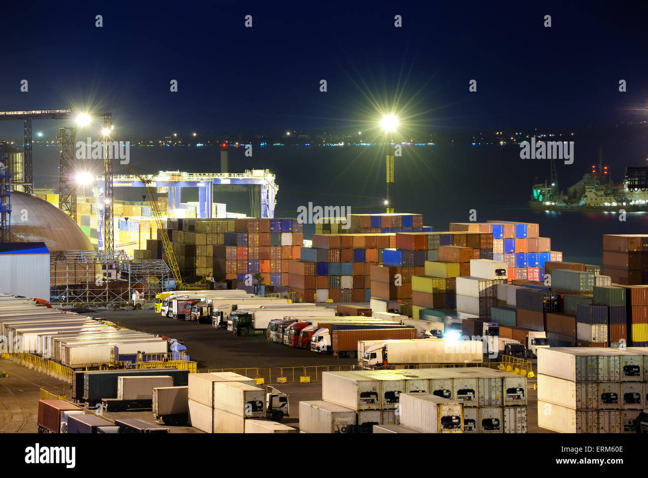 Port warehouse with cargoes and containers at night Stock Photo - Alamy