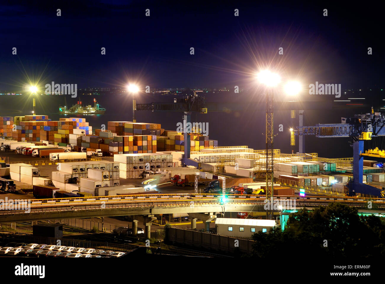 Port warehouse with cargoes and containers at night Stock Photo - Alamy