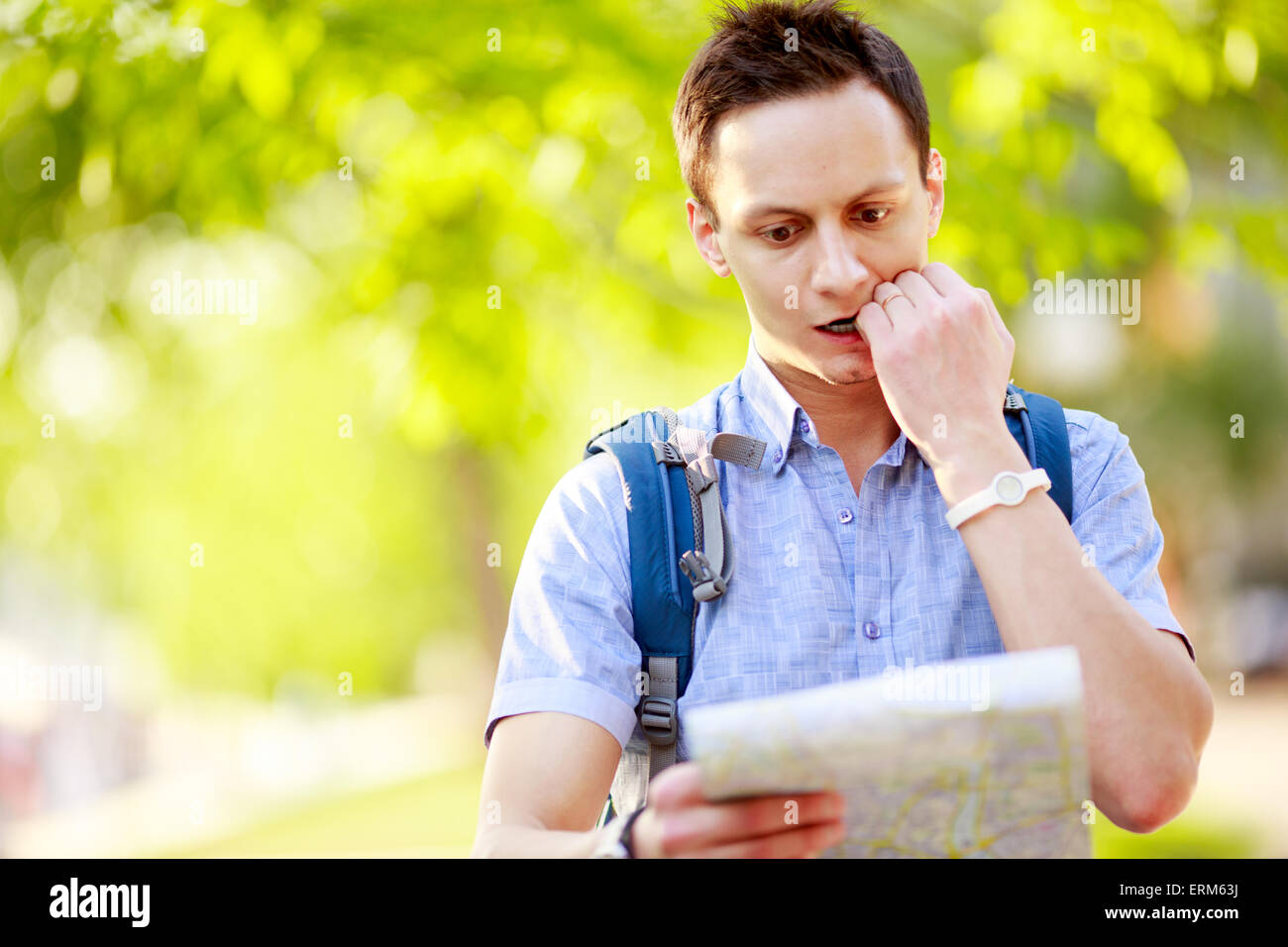 Young man with a map outdoors Stock Photo - Alamy