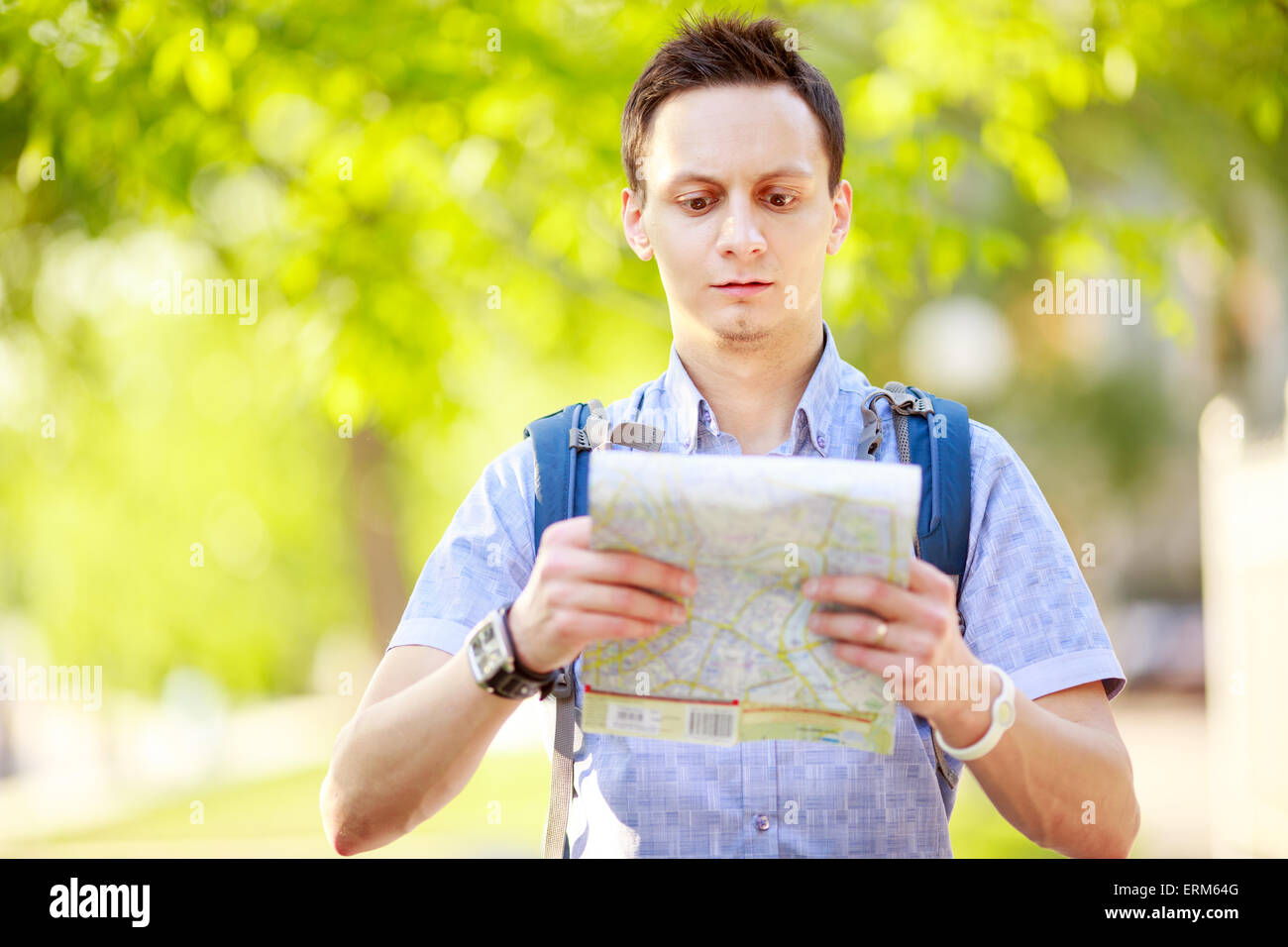 Young man with a map outdoors Stock Photo - Alamy