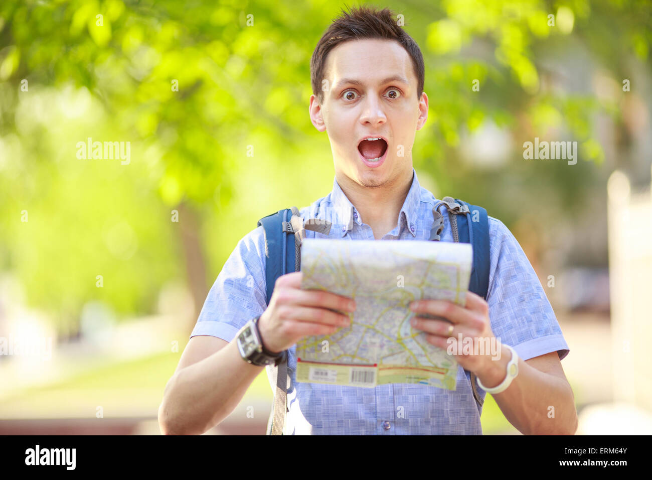 Young man with a map outdoors Stock Photo - Alamy
