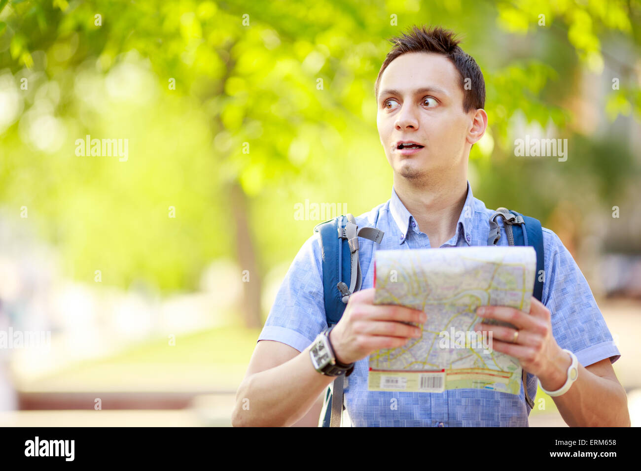 Young man with a map outdoors Stock Photo - Alamy