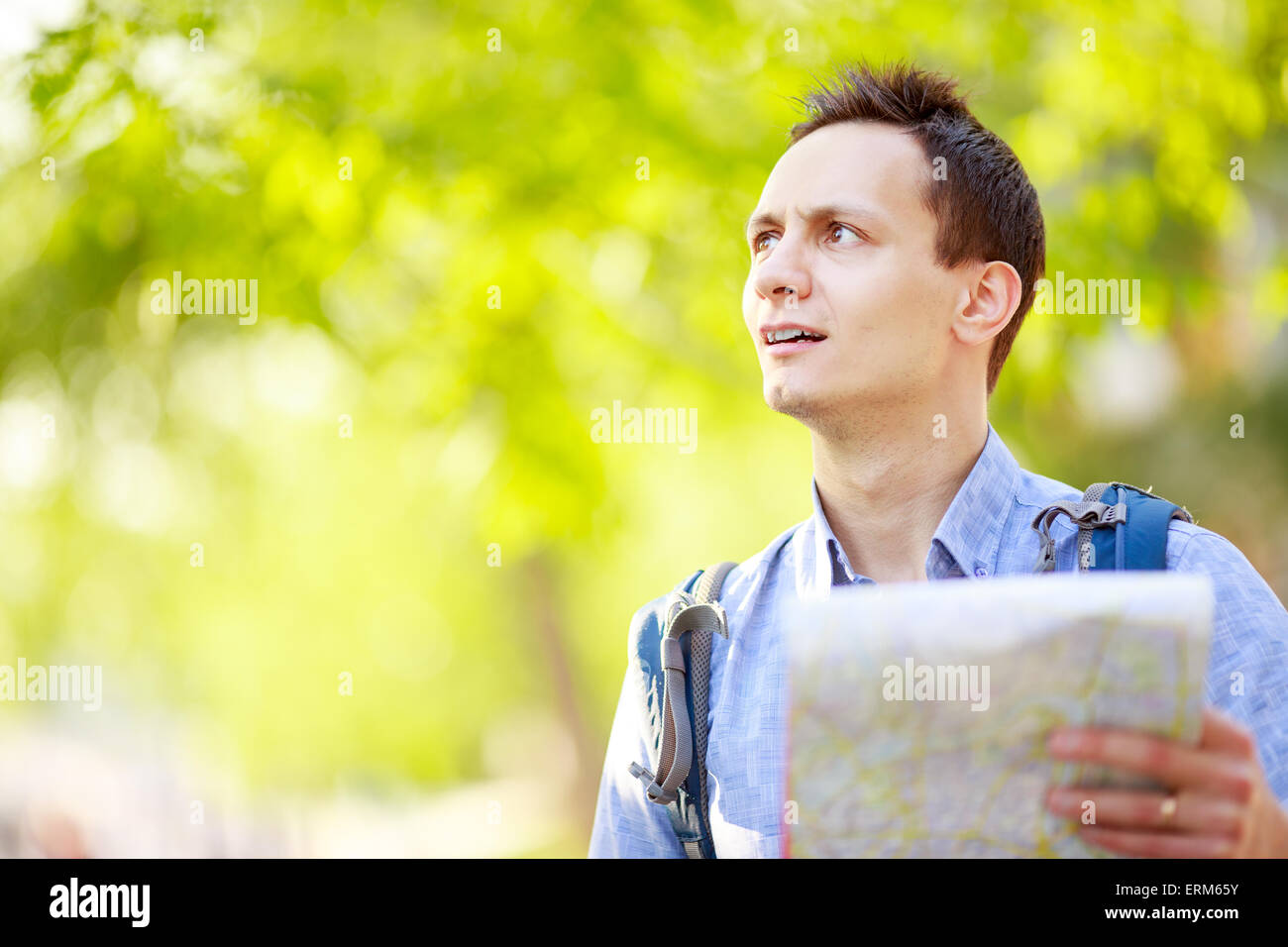 Young man with a map outdoors Stock Photo - Alamy