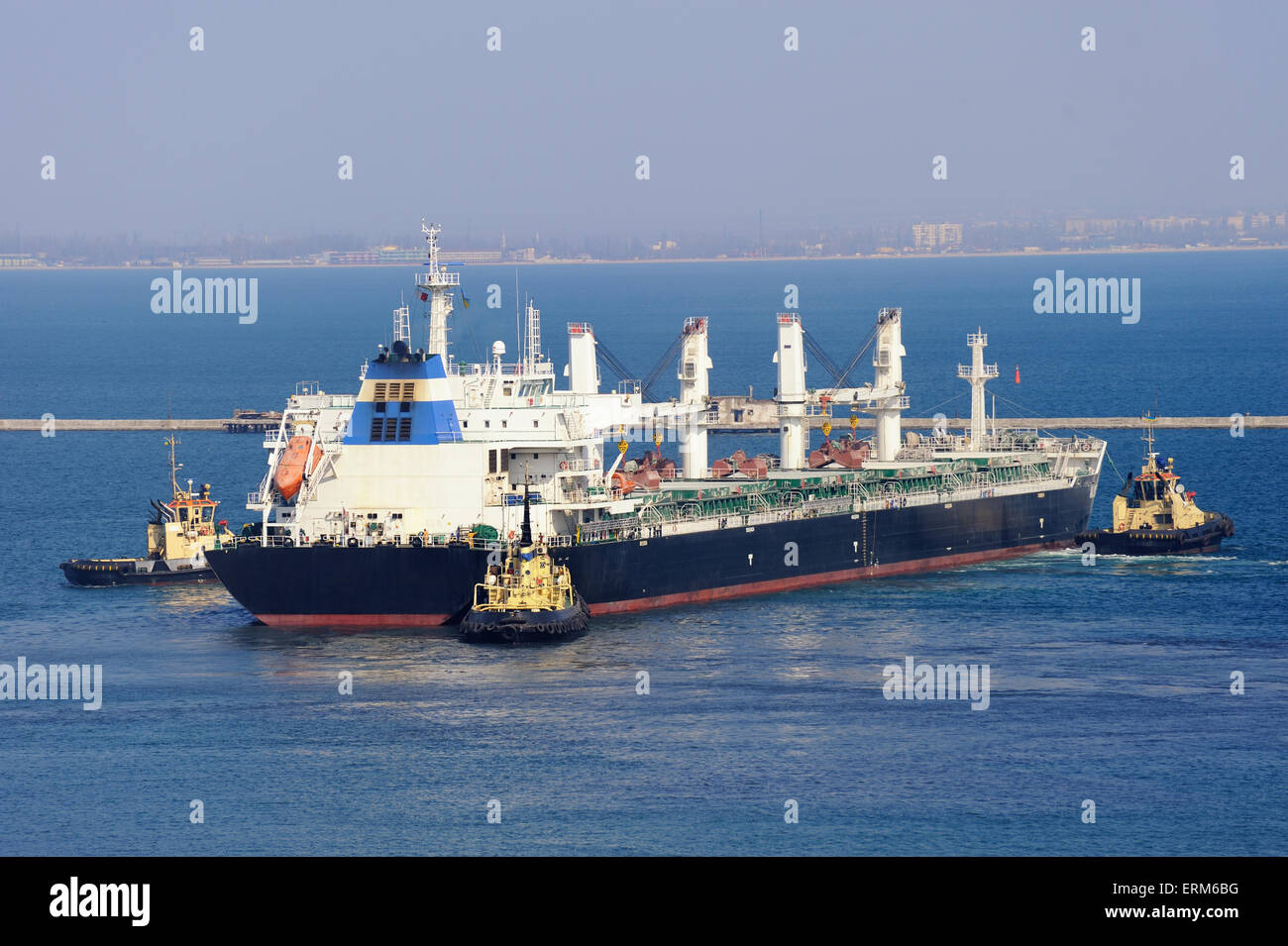 cargo ship and tug boats Stock Photo - Alamy