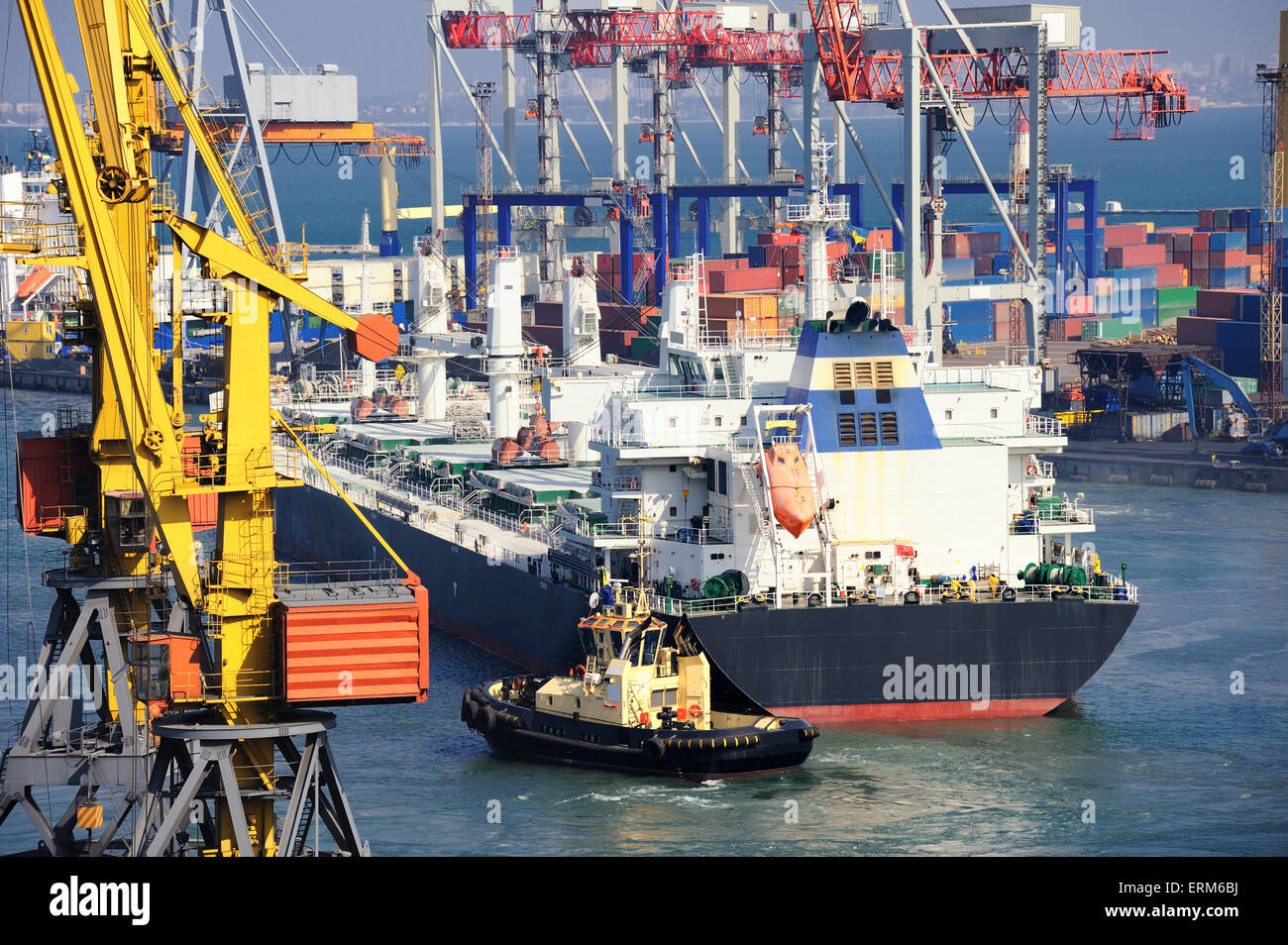 cargo ship and tug boat in port Stock Photo - Alamy