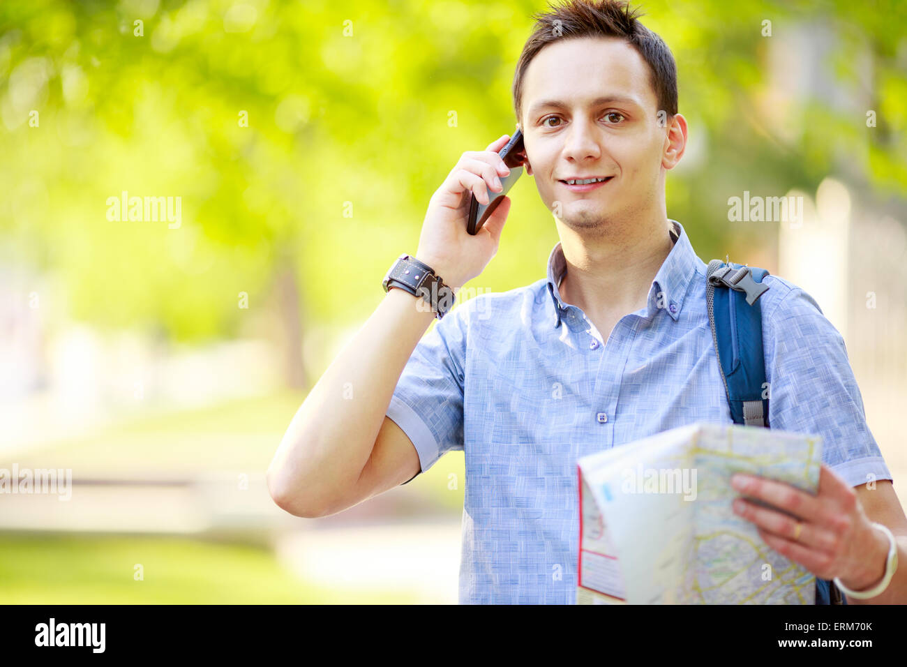 Man holding map outdoors and talking by phone Stock Photo - Alamy