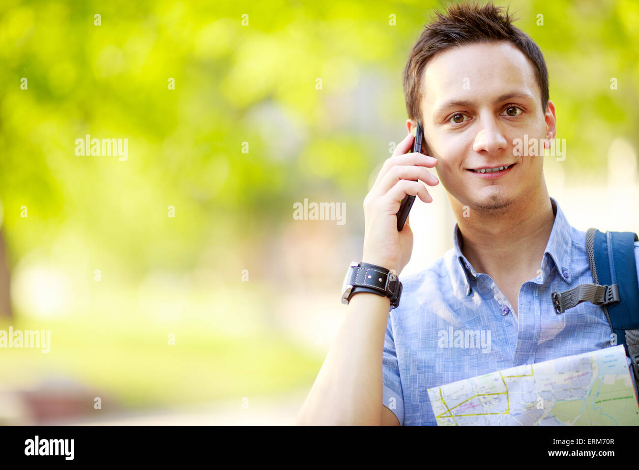 Man holding map outdoors and talking by phone Stock Photo - Alamy