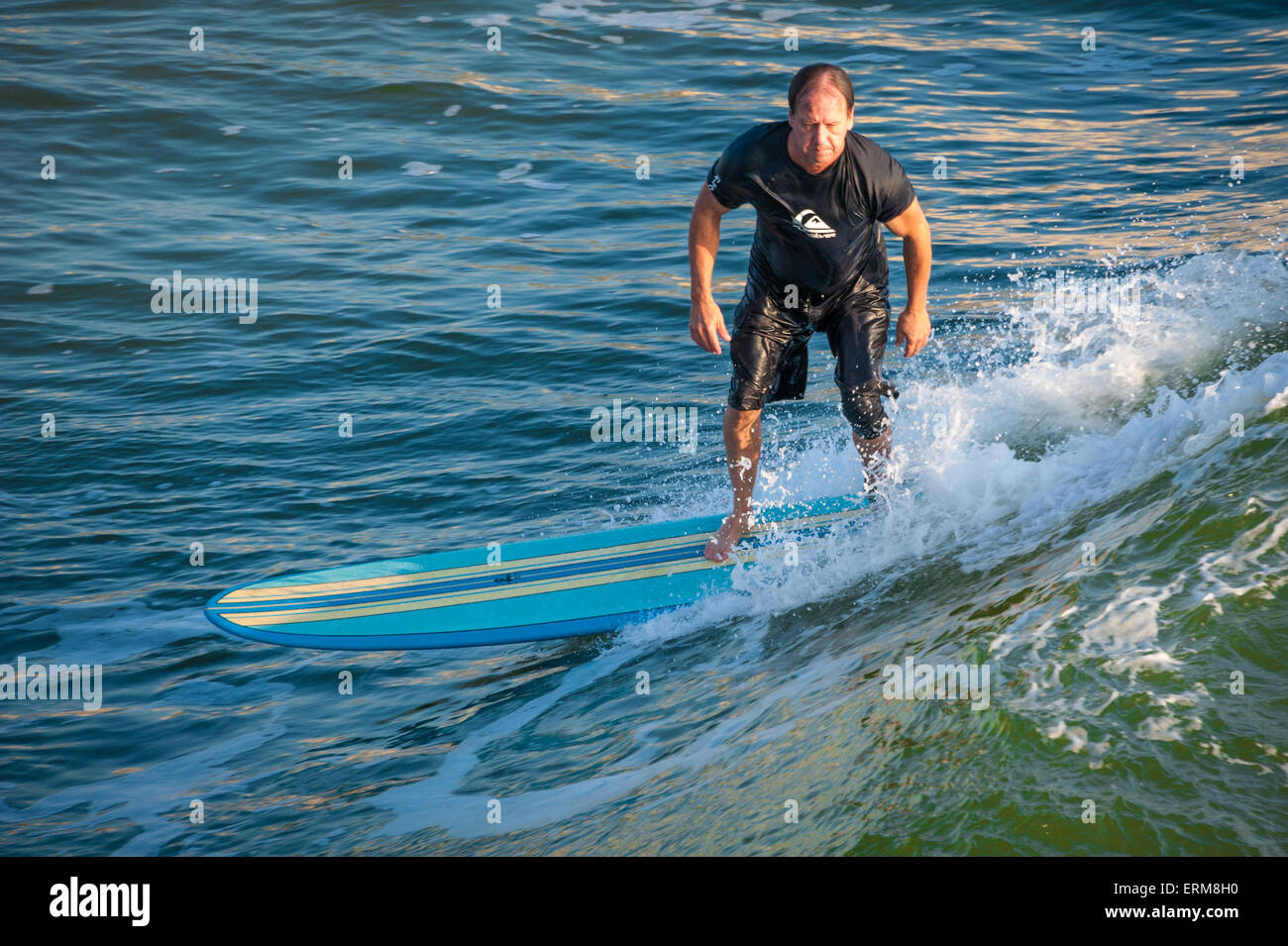 Surfer catching an early morning wave at Jacksonville Beach, Florida ...