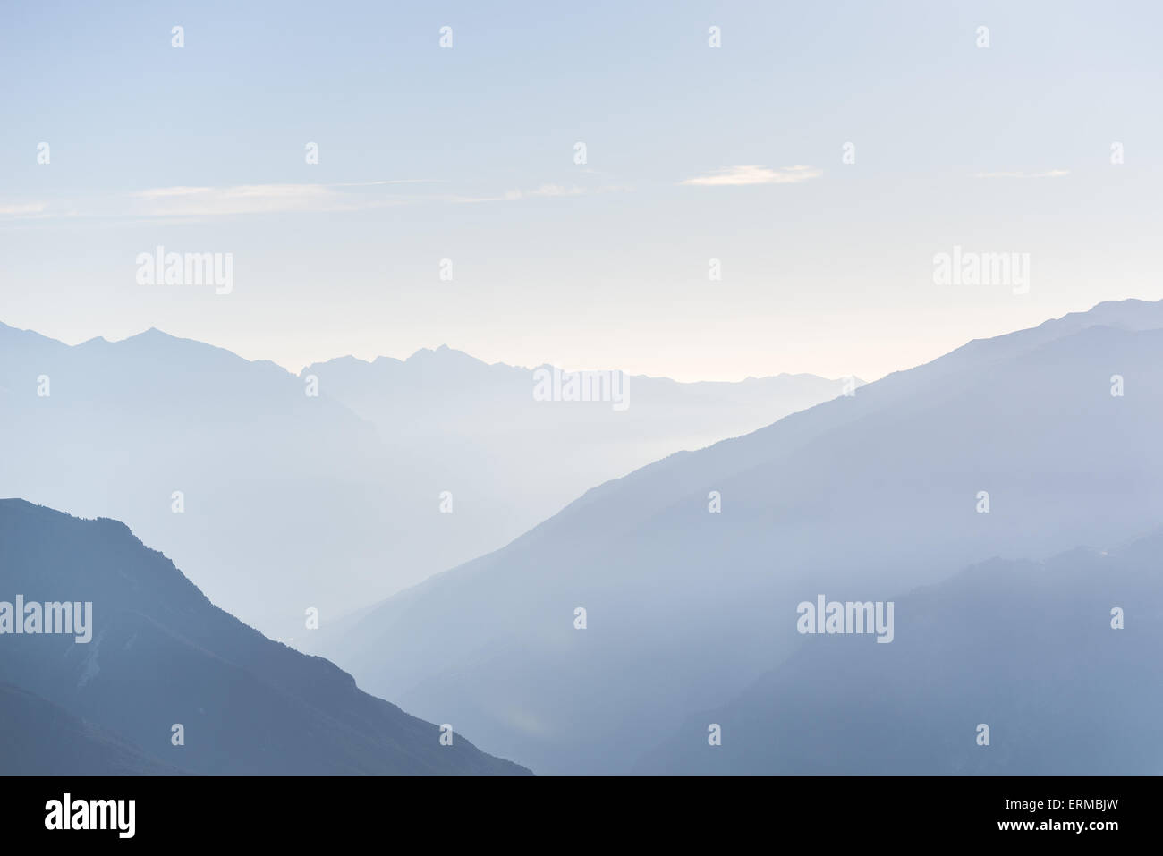 Telephoto view of distant blue toned mountain range at sunrise with ...