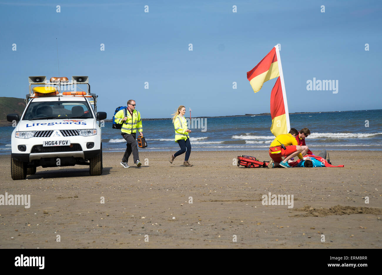 Rnli and paramedic first responers treat casualty on the beach Stock ...