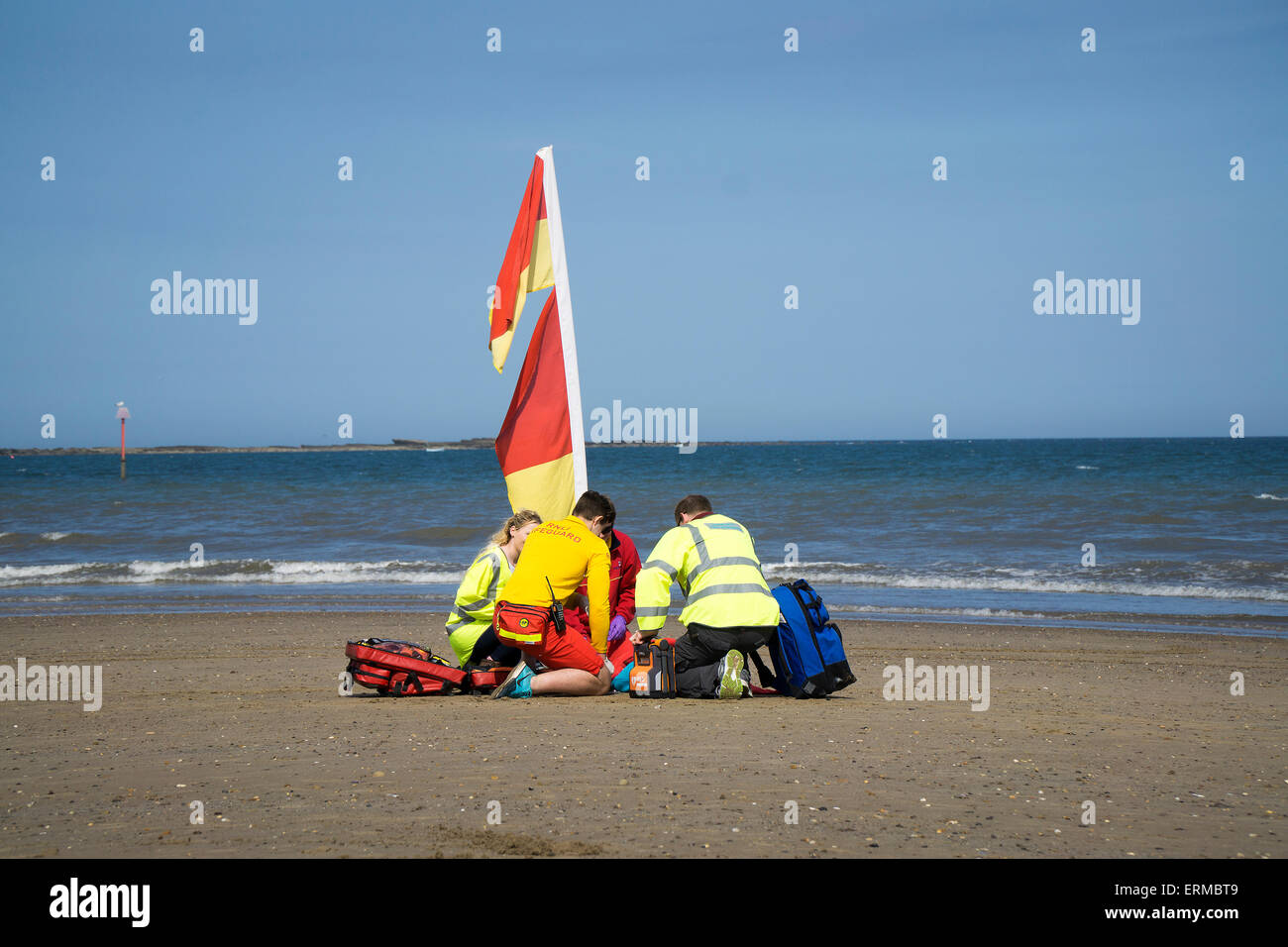Rnli and paramedic first responers treat casualty on the beach Stock ...