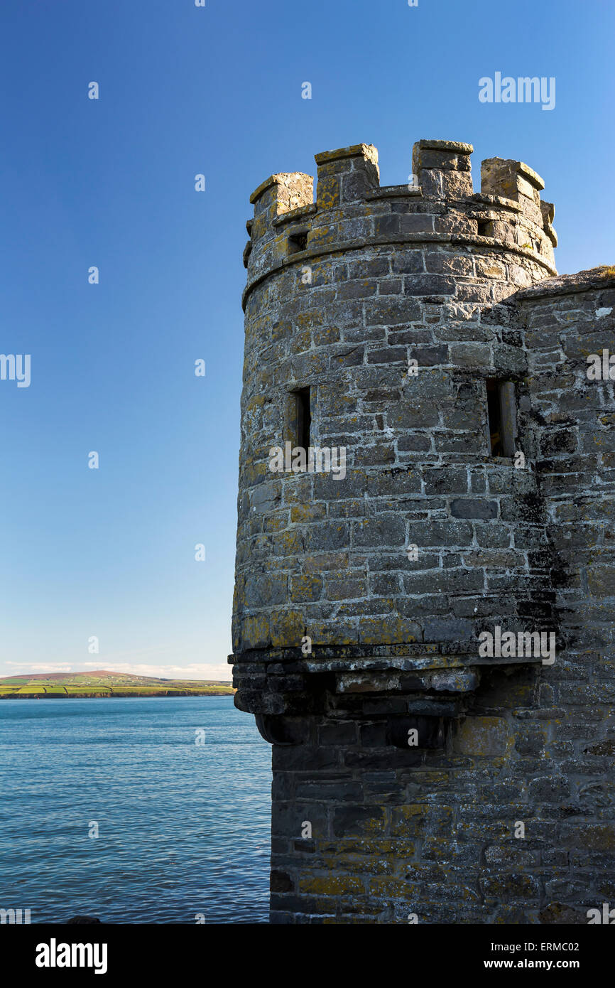 Stone wall with turret at water's edge and blue sky; Carrigaholt ...