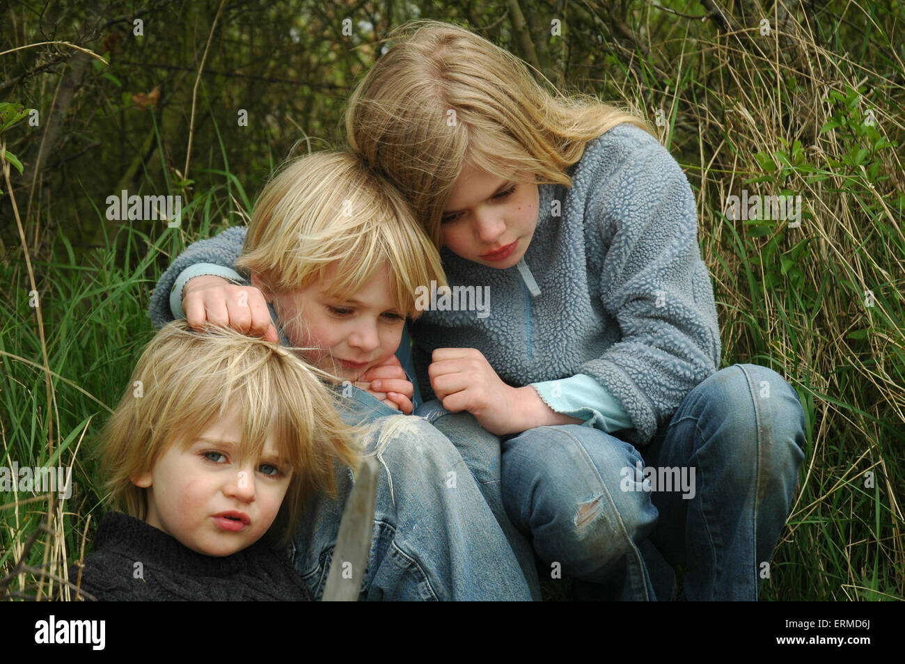 Three very cold children cuddle to try and keep warm Stock Photo - Alamy