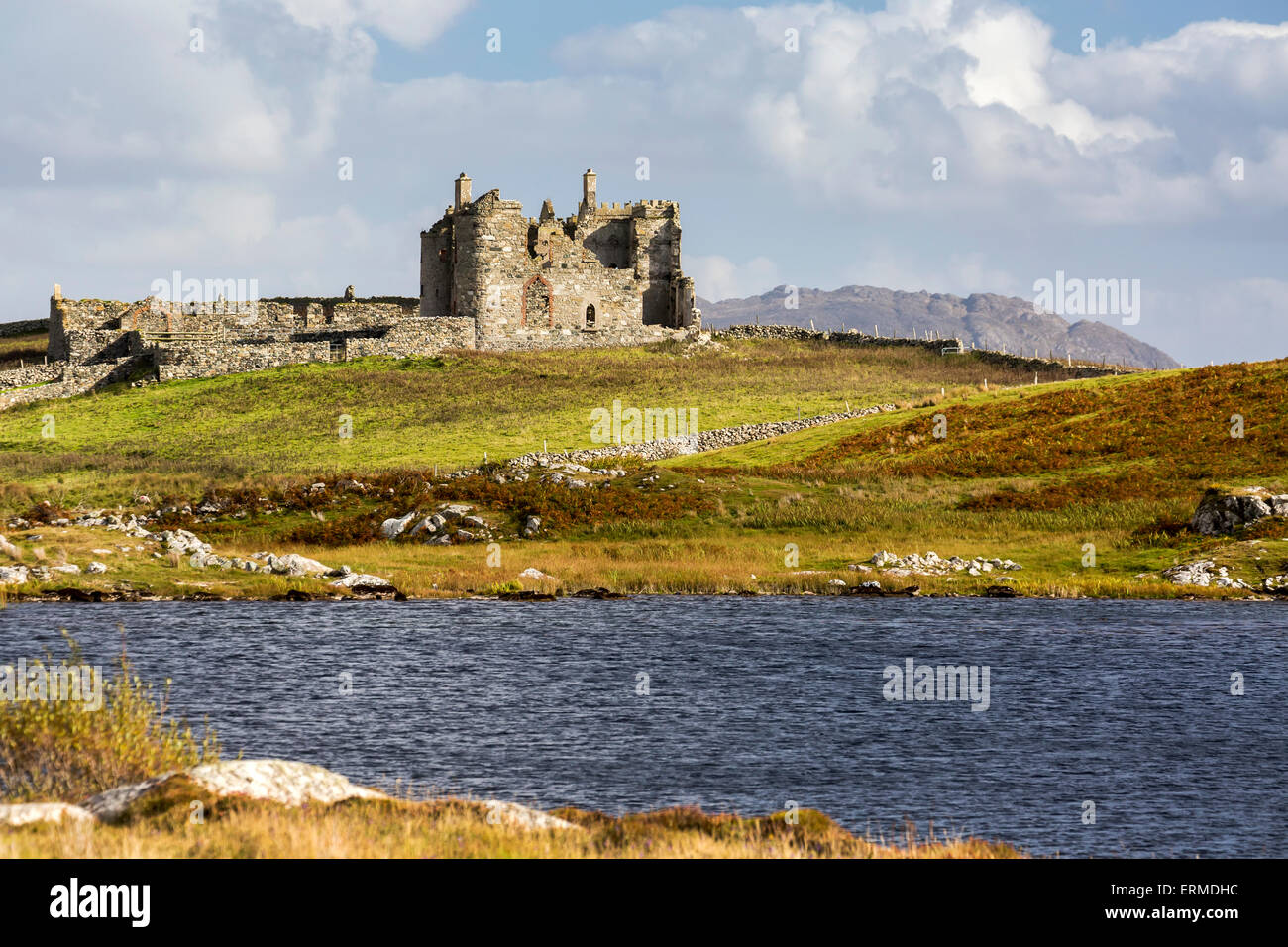 Ruined stone castle on rolling hill with pond in the foreground and ...