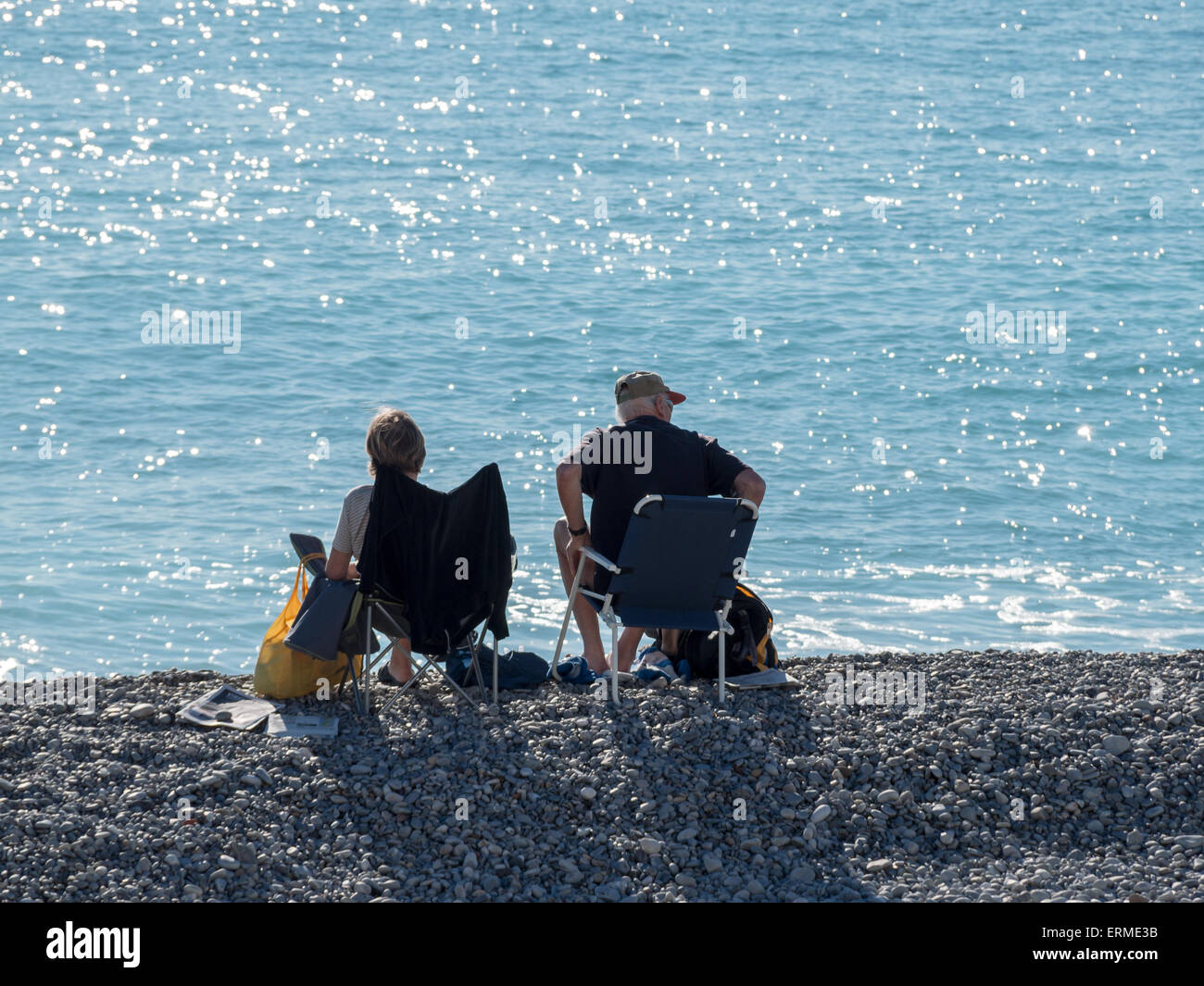 Getting some winter sun in Nice's beach Stock Photo - Alamy
