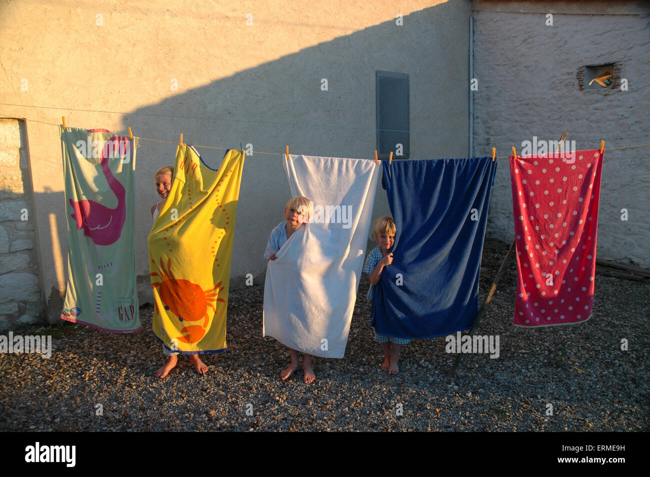 Some children hide behind washing hanging on a washing line Stock Photo ...