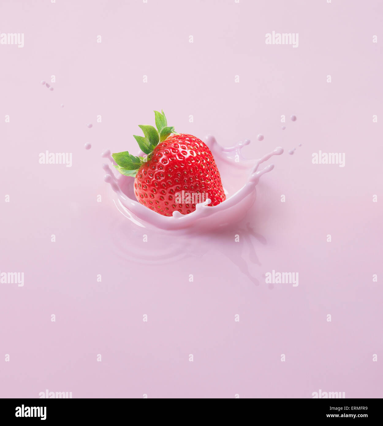 A strawberry splashing into pink liquid Stock Photo - Alamy