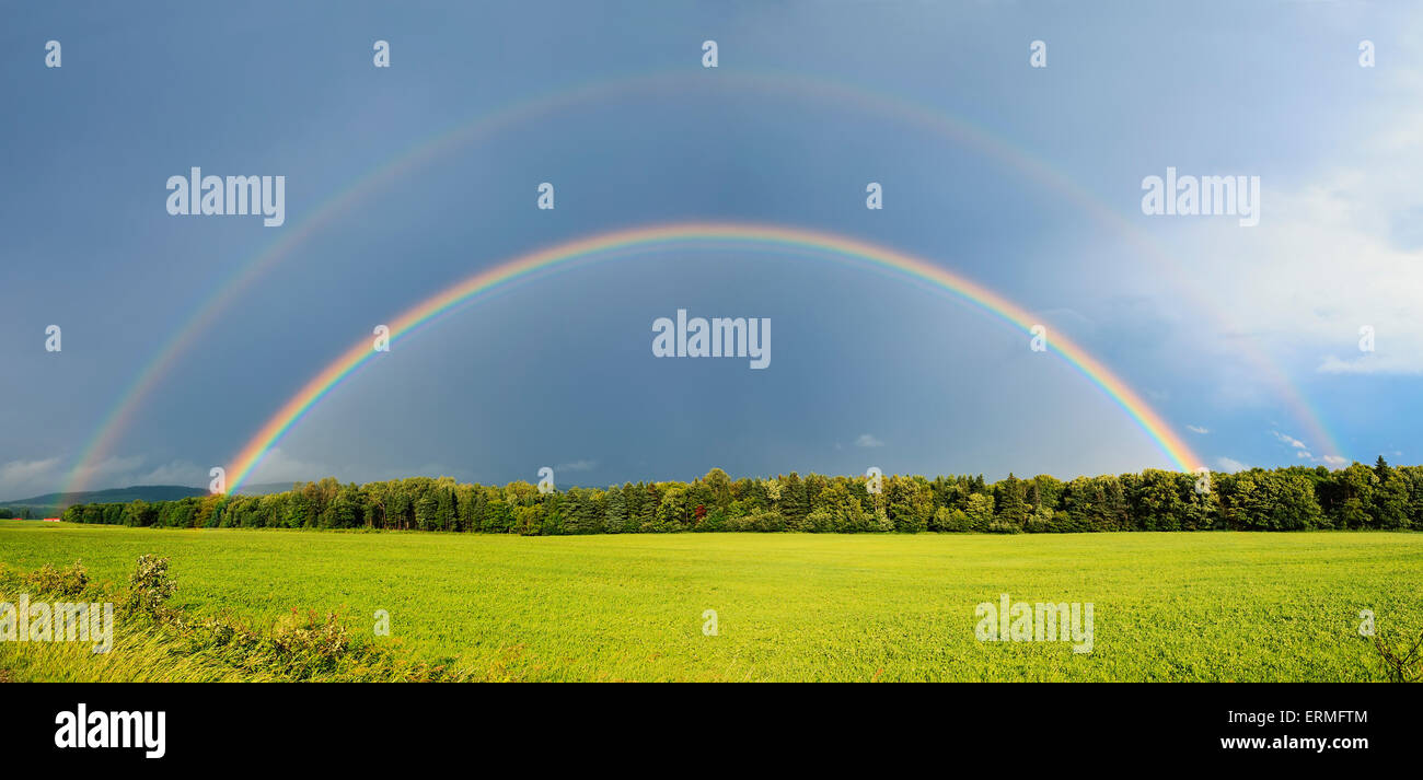 Double rainbow over trees and lush green field; Quebec, Canada Stock ...