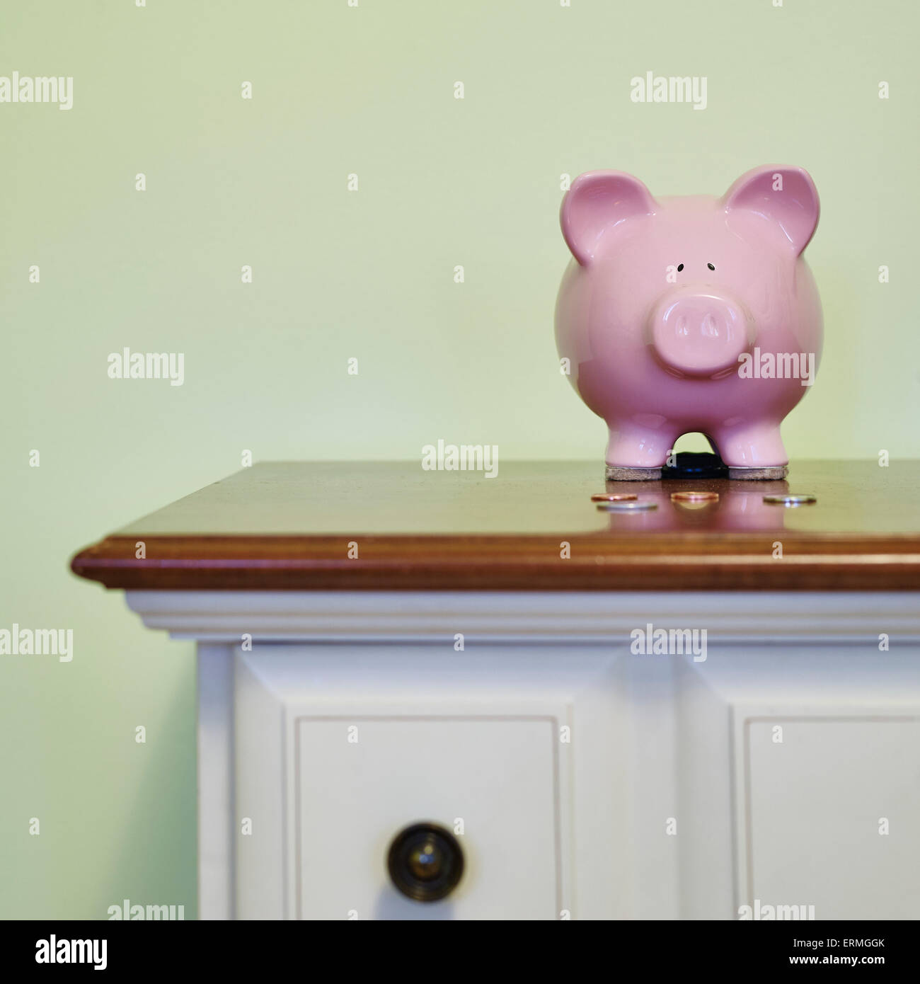 Pink piggy bank and a few coins on top of dresser; Ontario, Canada ...