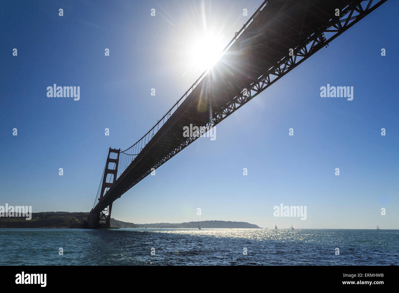 Sun, partially blocked by span, of Golden Gate Bridge reflects on San ...