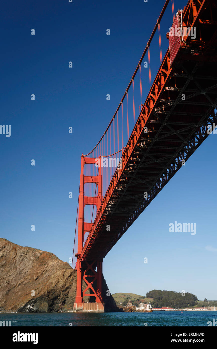 Long red span of Golden Gate bridge viewed from sailboat passing ...