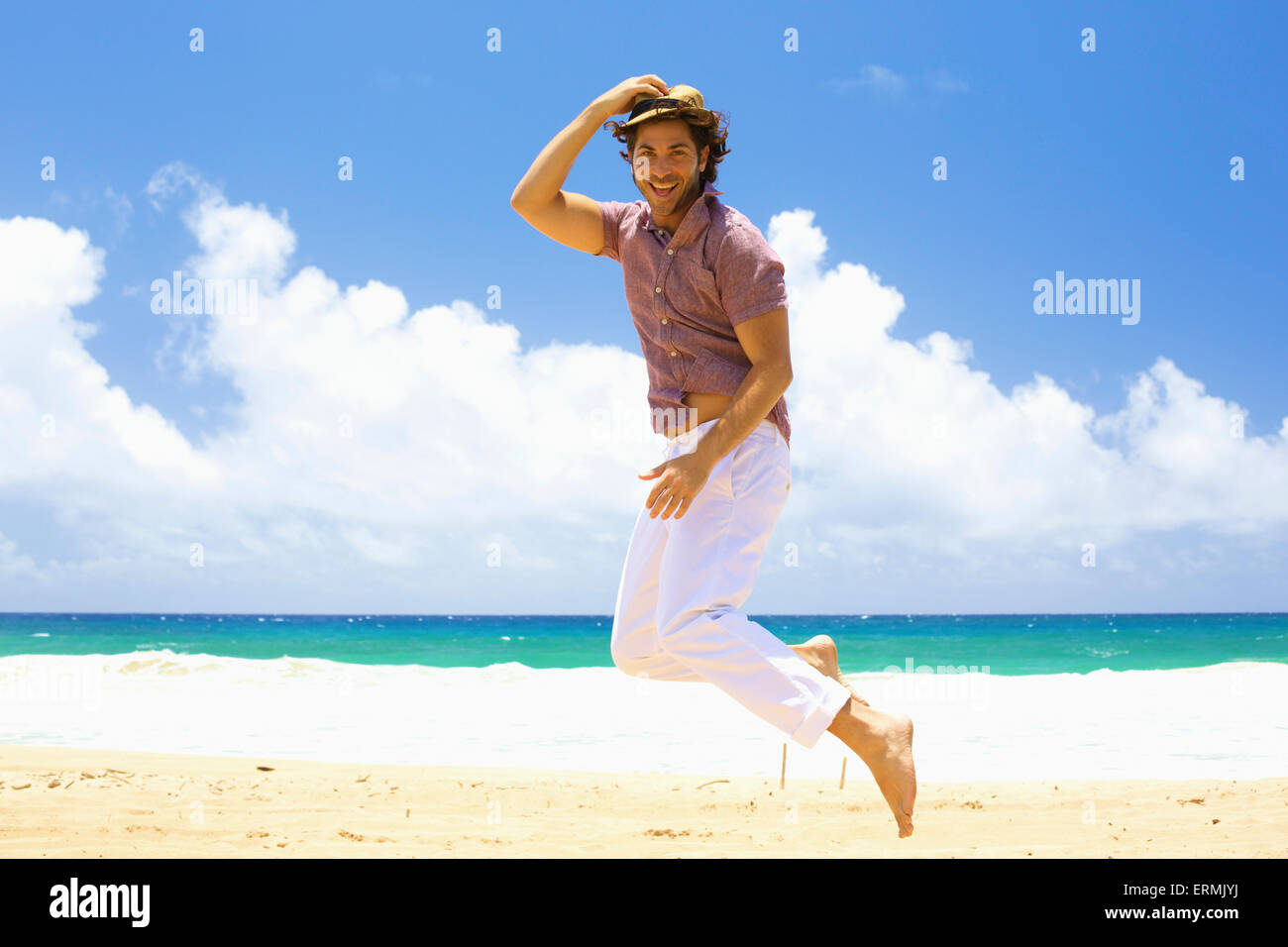 Man leaping in the air on the beach; Kealia, Kauai, Hawaii, United ...