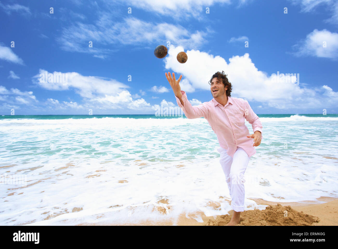 Man throwing coconuts on the beach; Kealia, Kauai, Hawaii, United ...