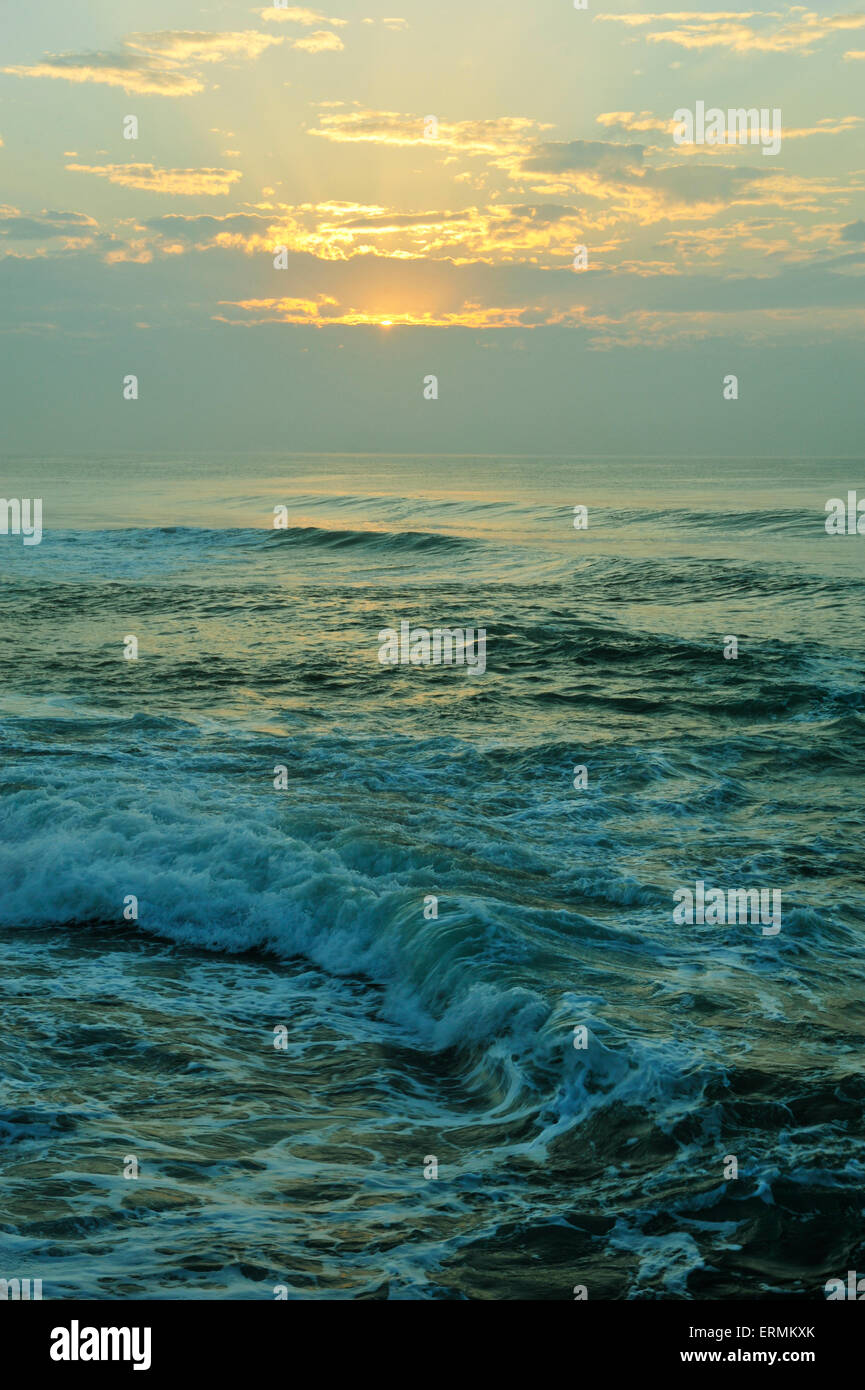 Beautiful golden light from sunrise reflecting on clouds over ocean ...