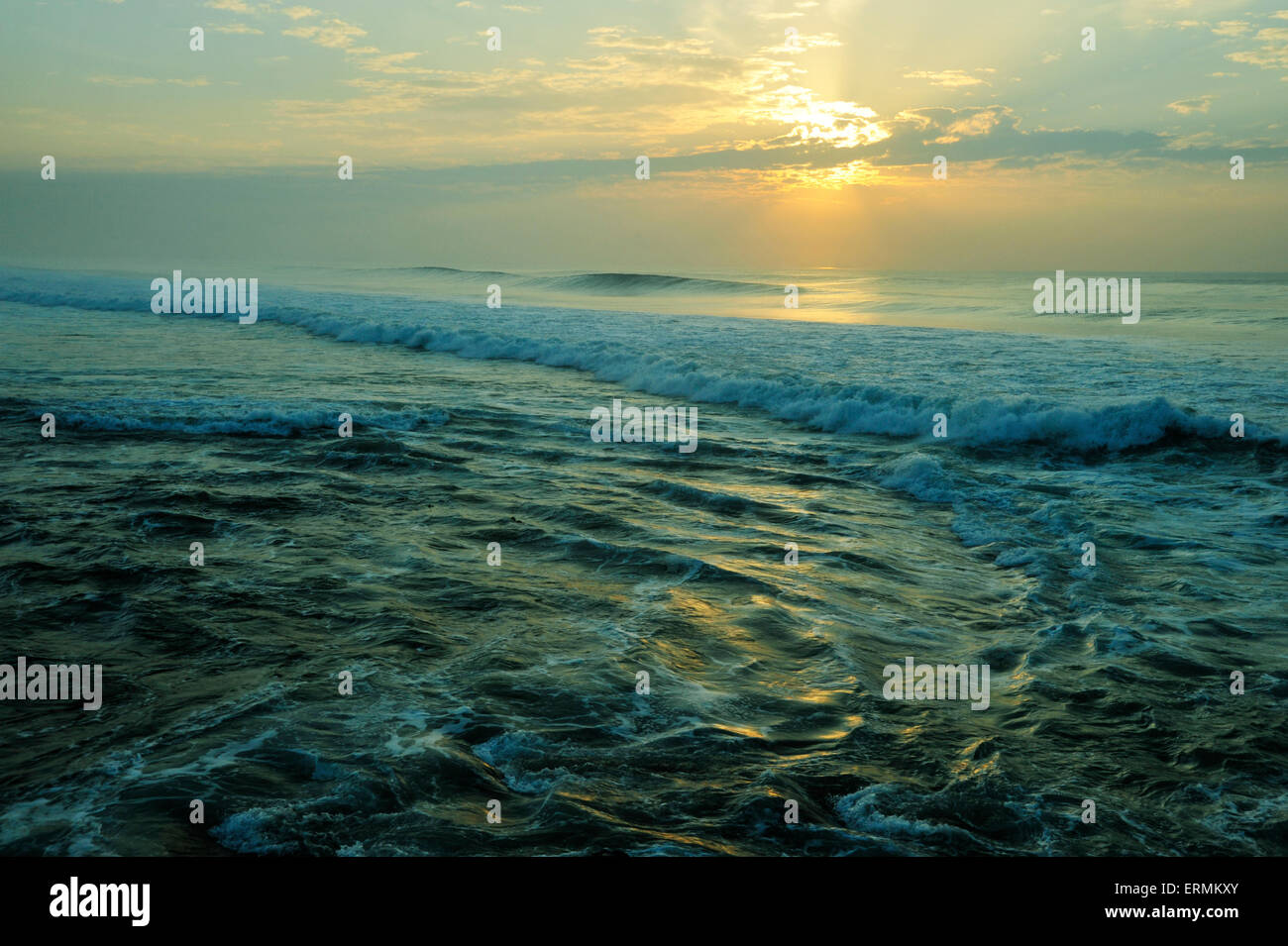 Morning seascape scene of sun rising over gentle waves of calm ocean ...