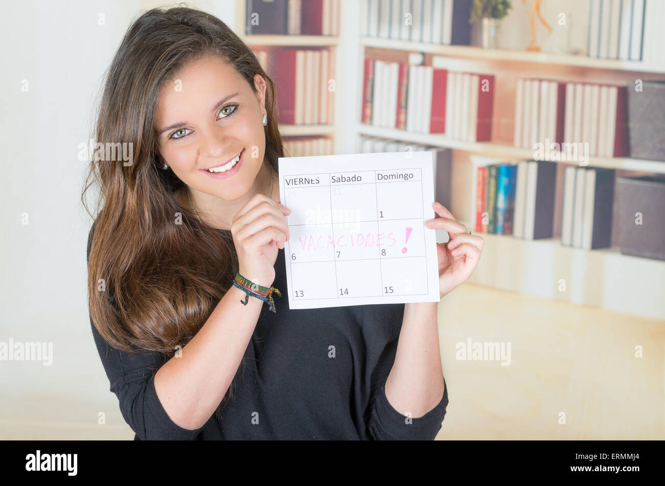 portrait of pretty brunette girl holding up a calendar Stock Photo - Alamy