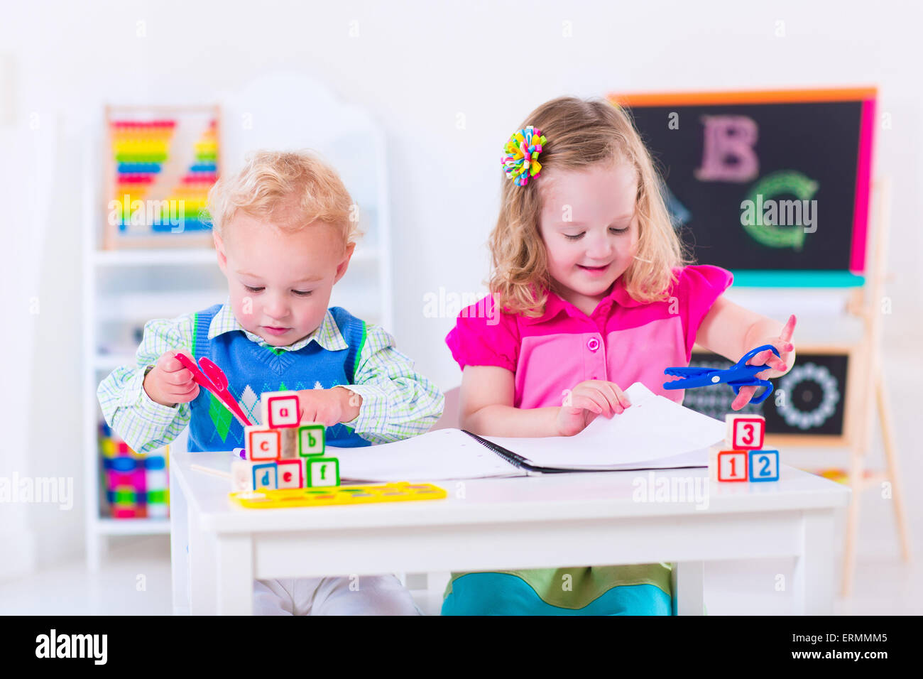 Kids at preschool. Two children drawing and painting at kindergarten ...